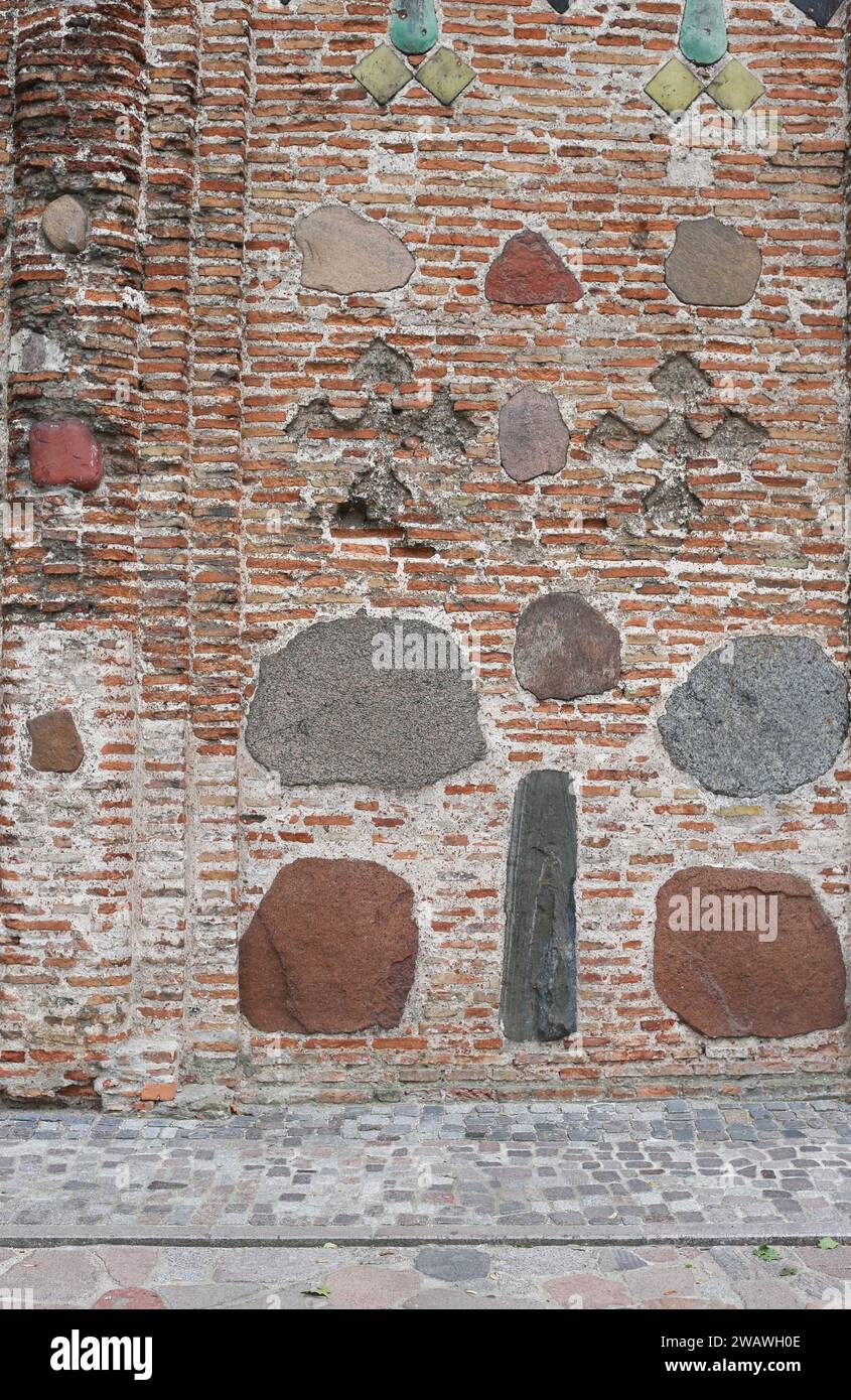cracked brick wall of rectangular red clay bricks and large stones ...