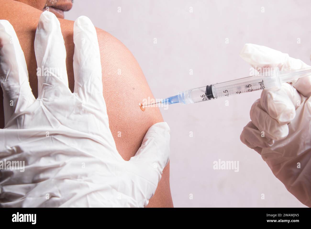 closeup, an old man is injected by a doctor in the upper arm, selective ...