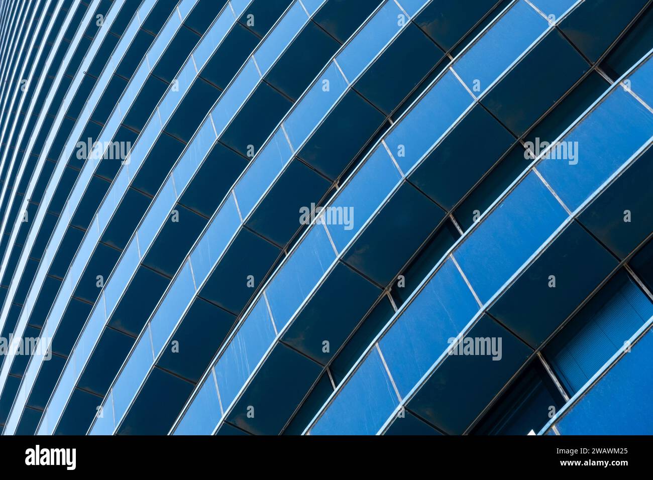 Diagonal intersection of blue glass skyscraper with reflections and ...