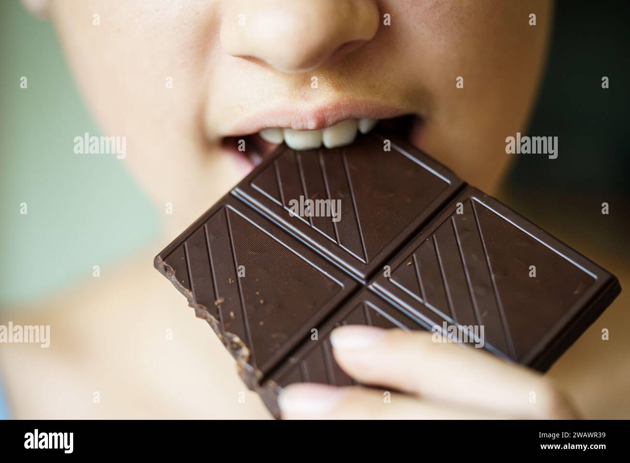 Unrecognizable young girl biting delicious chocolate bar Stock Photo ...