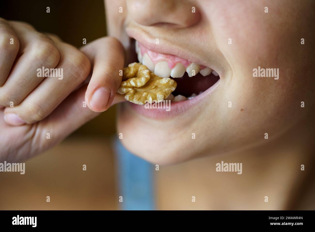 Crop unrecognizable teenage girl eating healthy walnut Stock Photo - Alamy