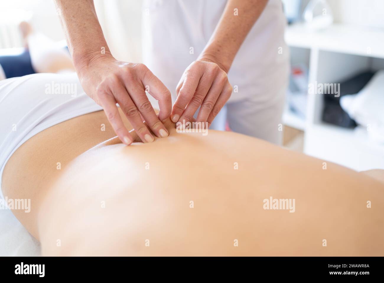 Professional masseuse massaging back of client Stock Photo - Alamy