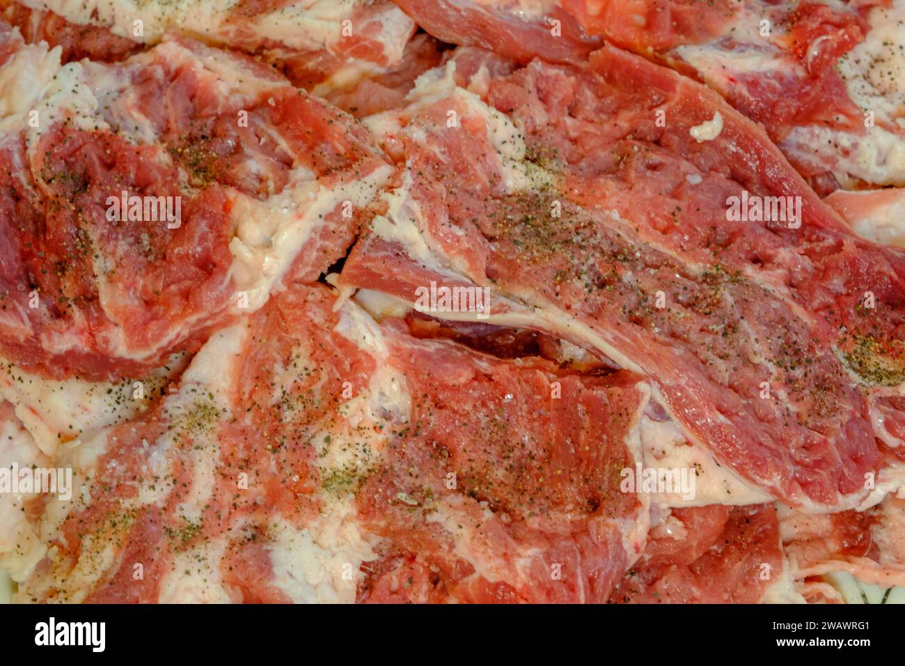 topping pork slices with fine pepper. Cut the pork into thin sheets for ...