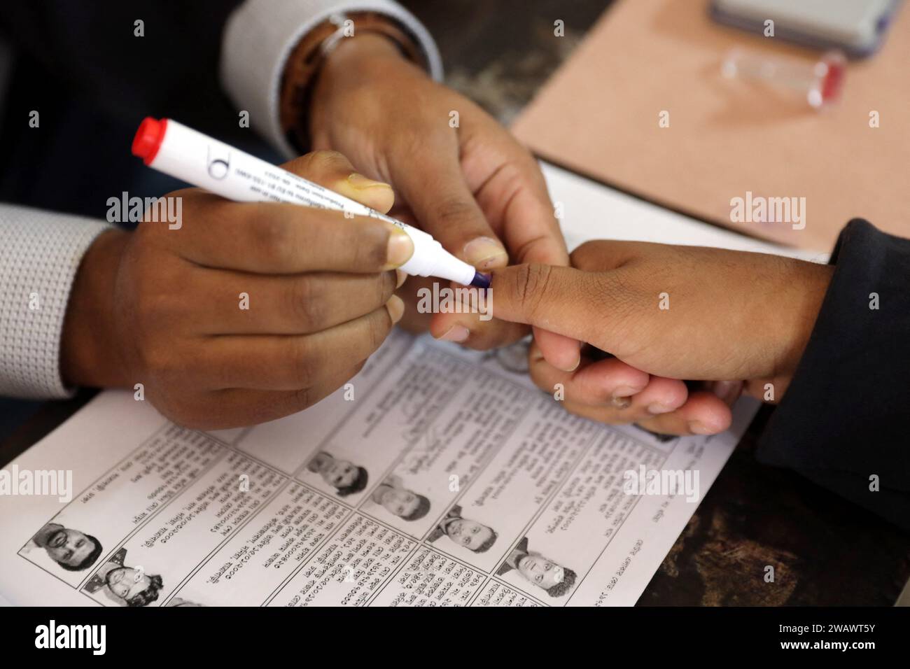 An official marks a voter's thumb at a polling center during the 12th ...