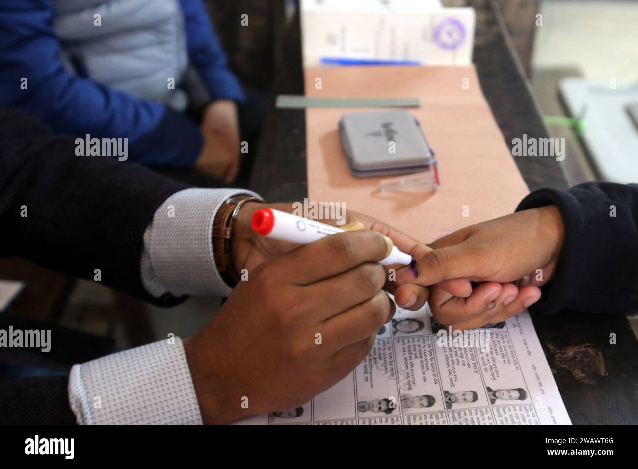 An official marks a voter's thumb at a polling center during the 12th ...