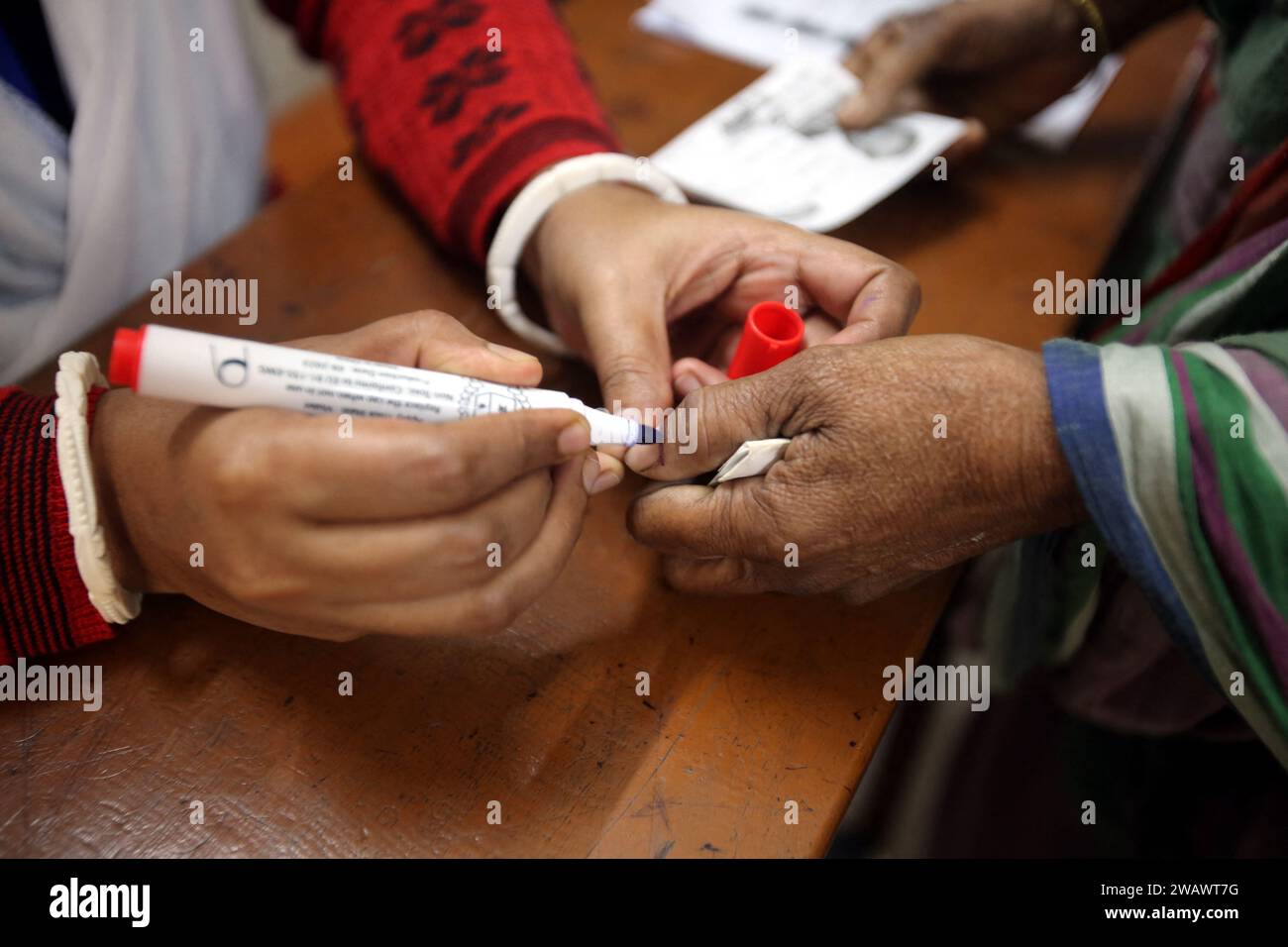 An official marks a voter's thumb at a polling center during the 12th ...