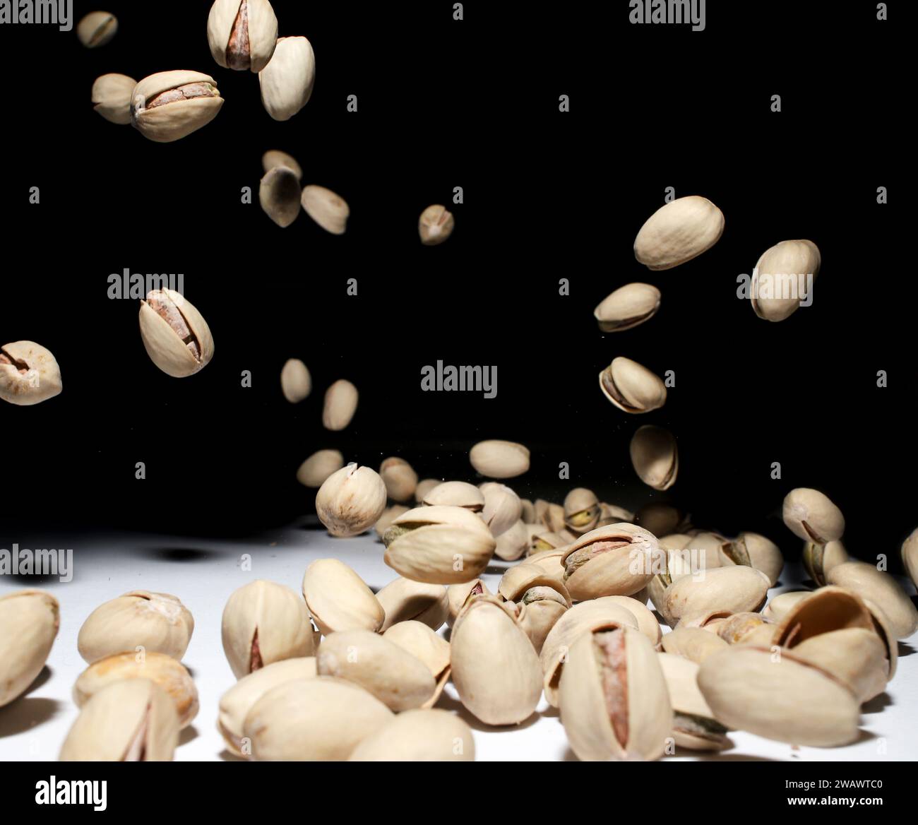 Pistachio nuts falling. In mid air on dark background. Frozen time ...