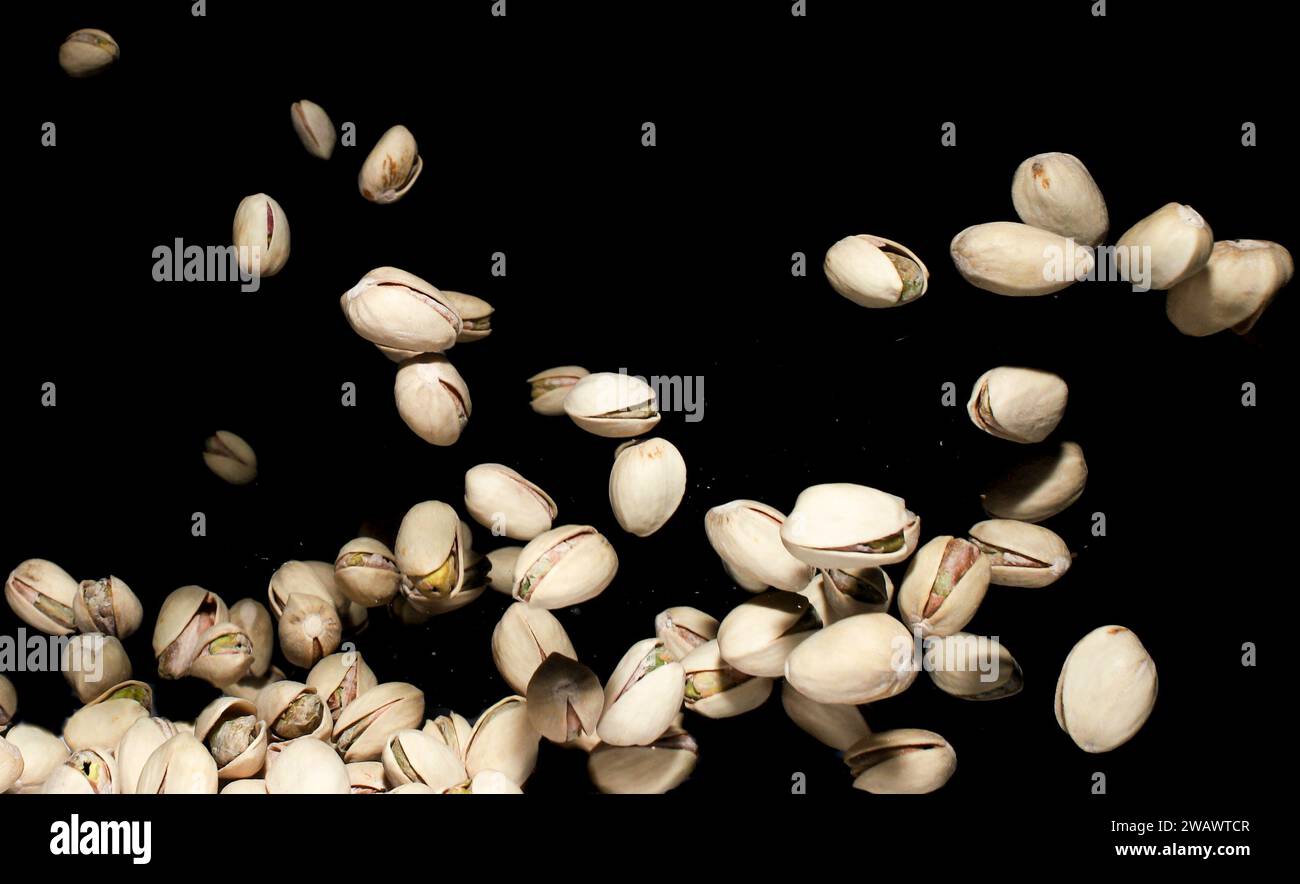 Pistachio nuts falling. In mid air on dark background. Frozen time ...