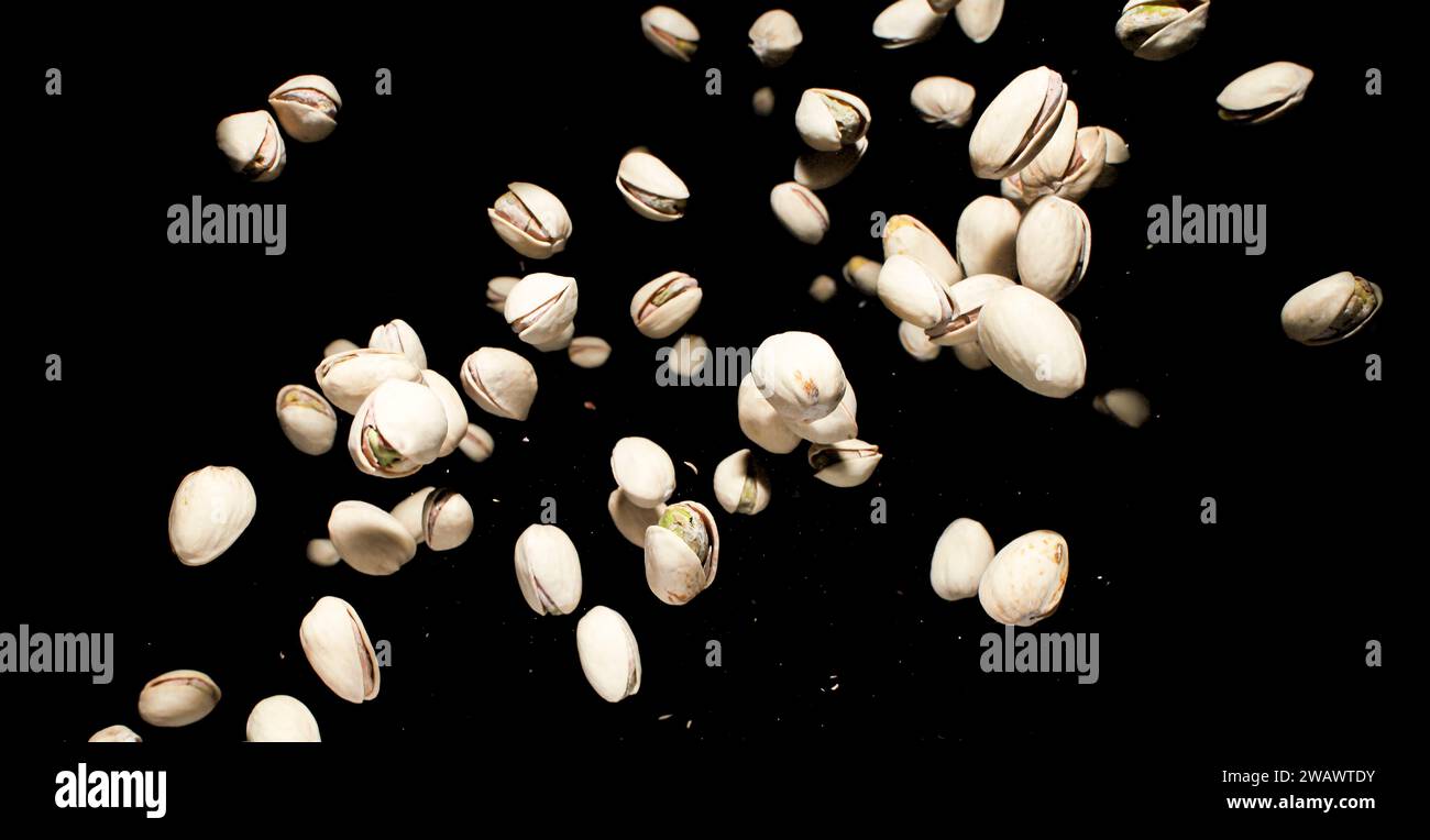 Pistachio nuts falling. In mid air on dark background. Frozen time ...