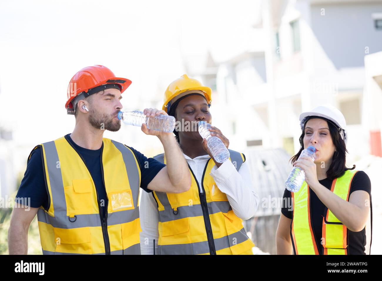 Healthy worker engineer team thirsty drinking clean water in hot temperature weather summer ...