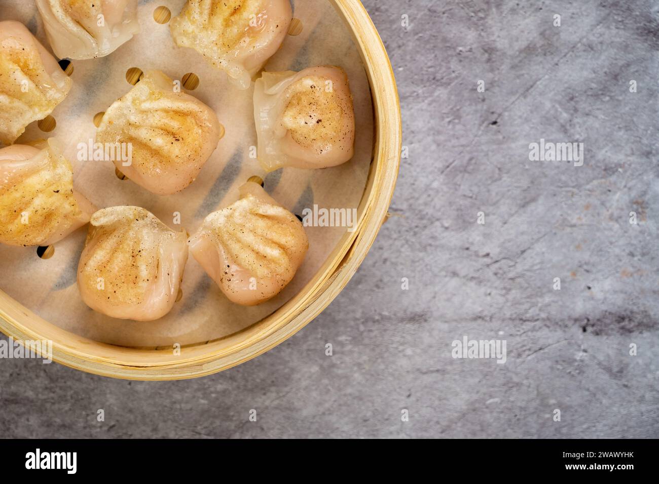 Homemade dumplings dim sum close-up in a bamboo steamer box on table ...