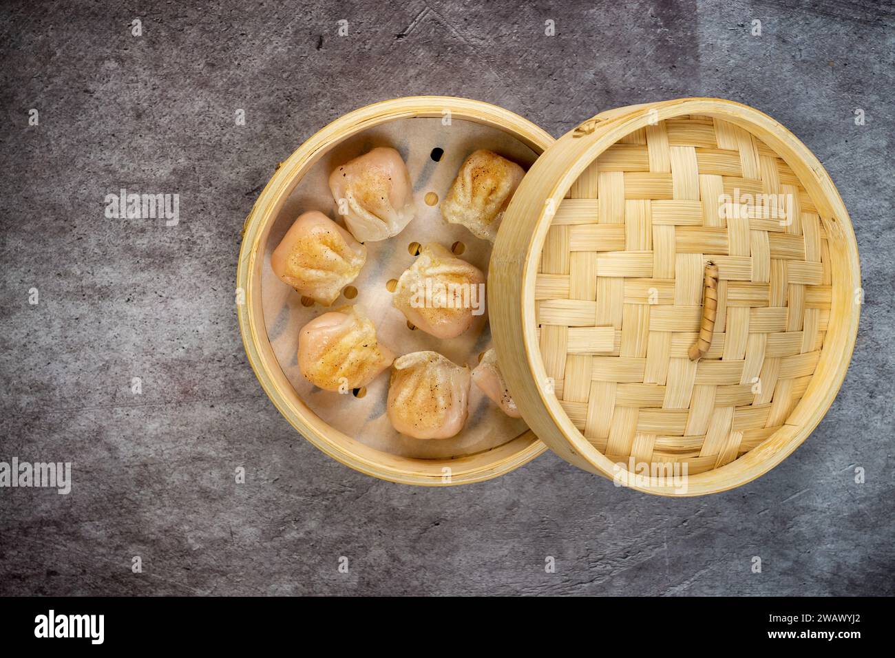 Homemade dumplings dim sum close-up in a bamboo steamer box on table ...