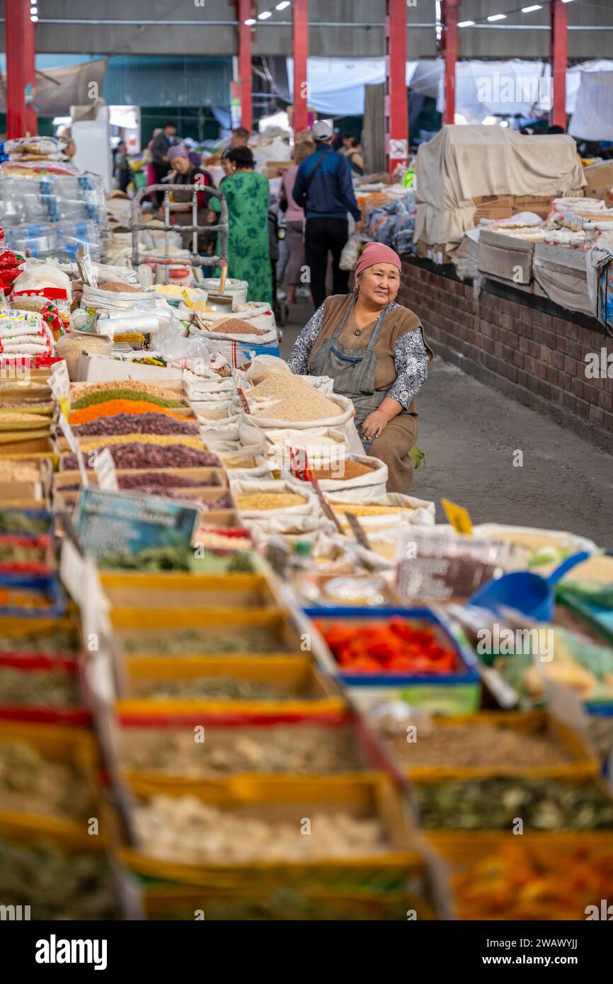 Traditional woman selling spices, flour and food, market stall at Osh ...