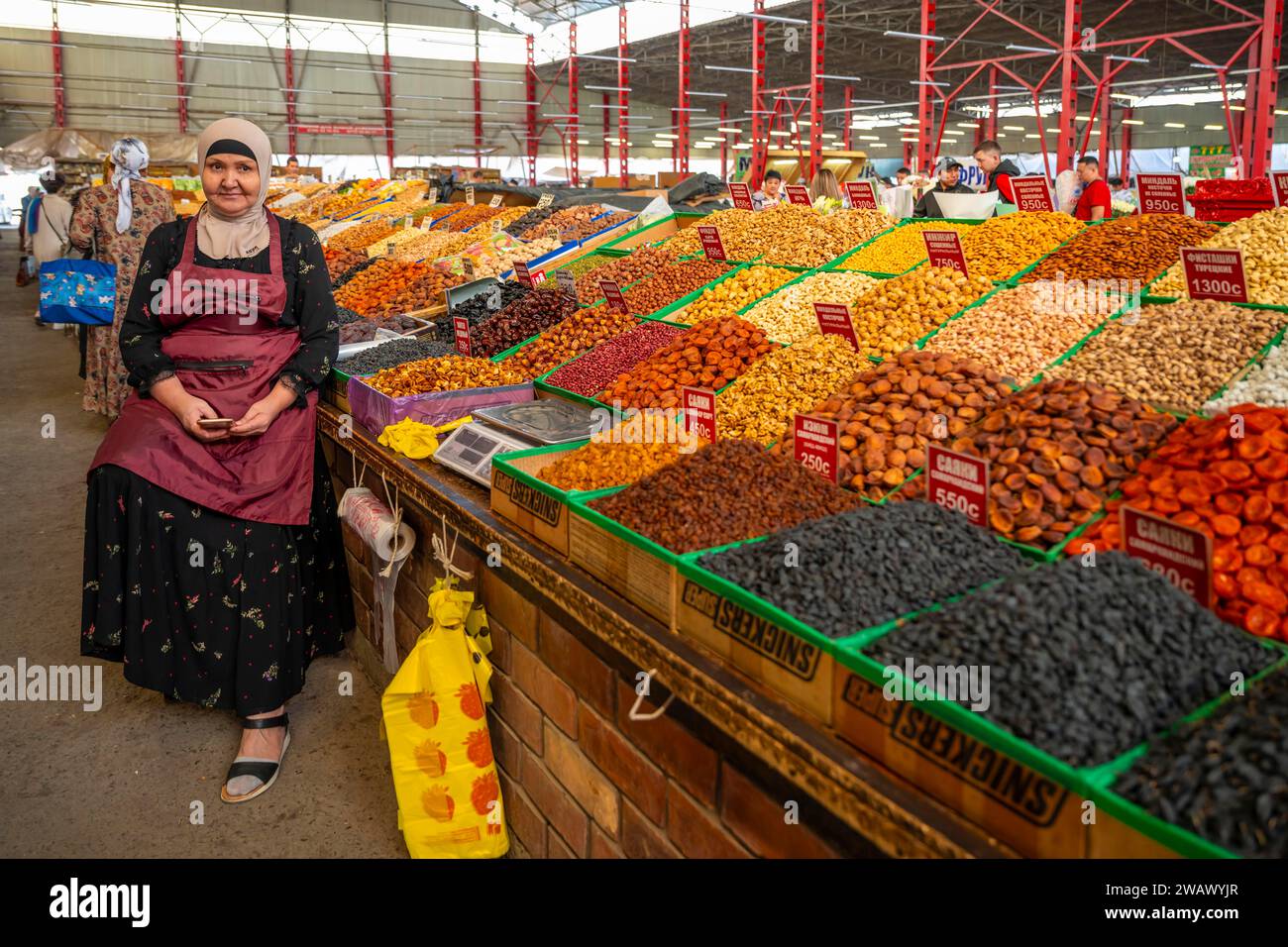 Vendor selling sweets, dried fruit and nuts, market stall at the Osh ...