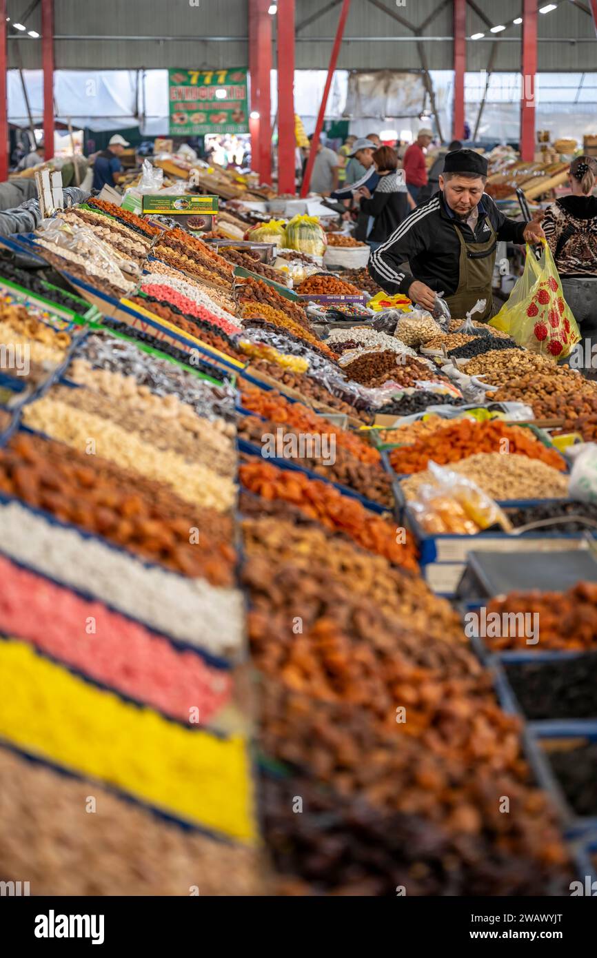 Vendor selling sweets, dried fruit and nuts, market stall at the Osh ...