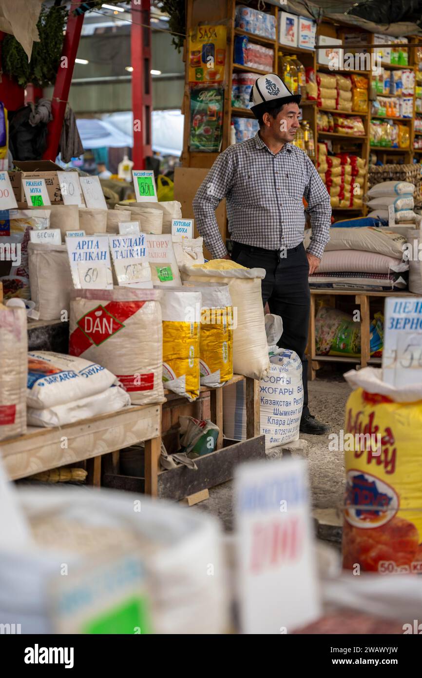 Traditional man selling spices, flour and food, market stall at Osh ...