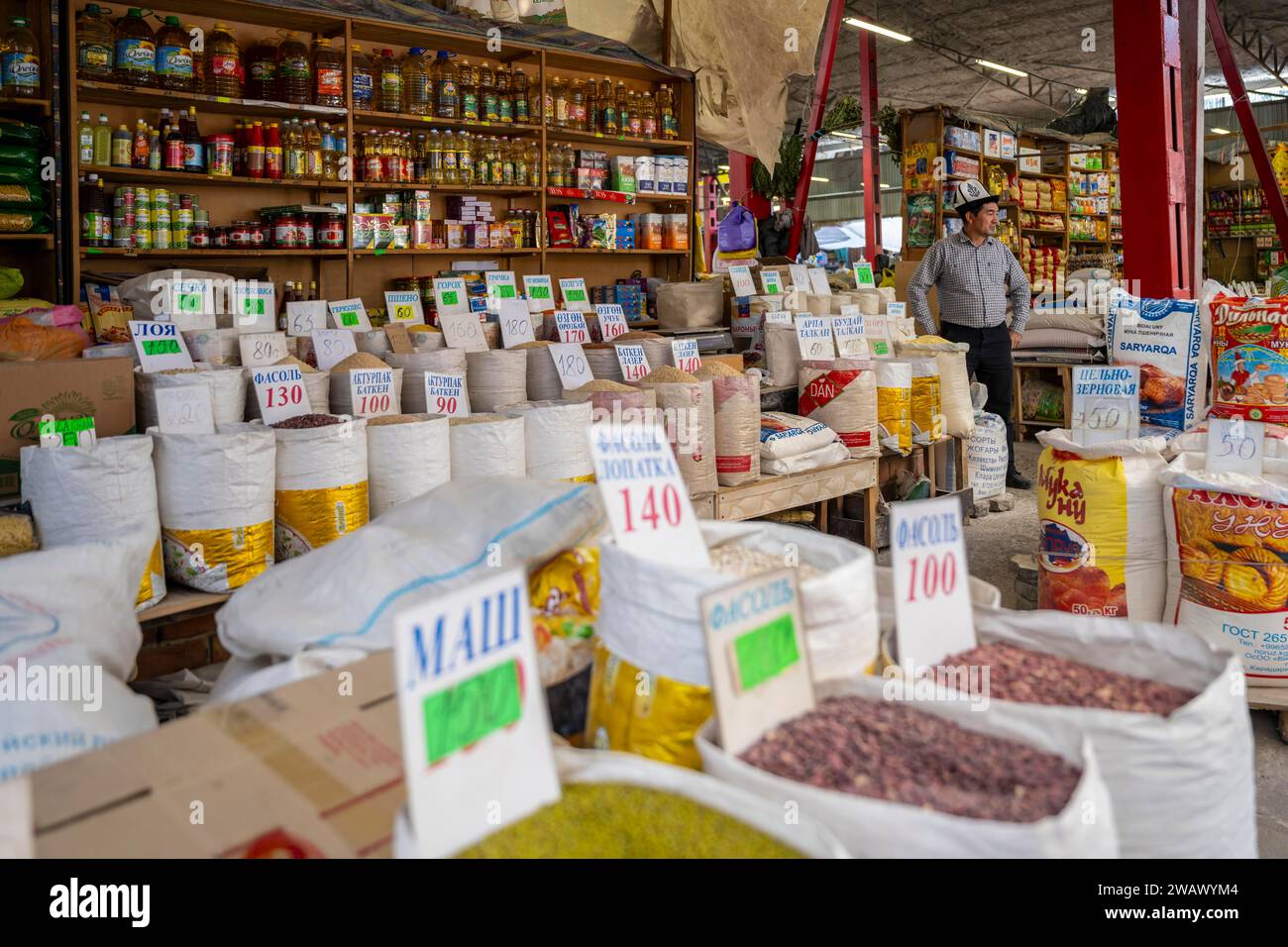 Traditional man selling spices, flour and food, market stall at Osh ...