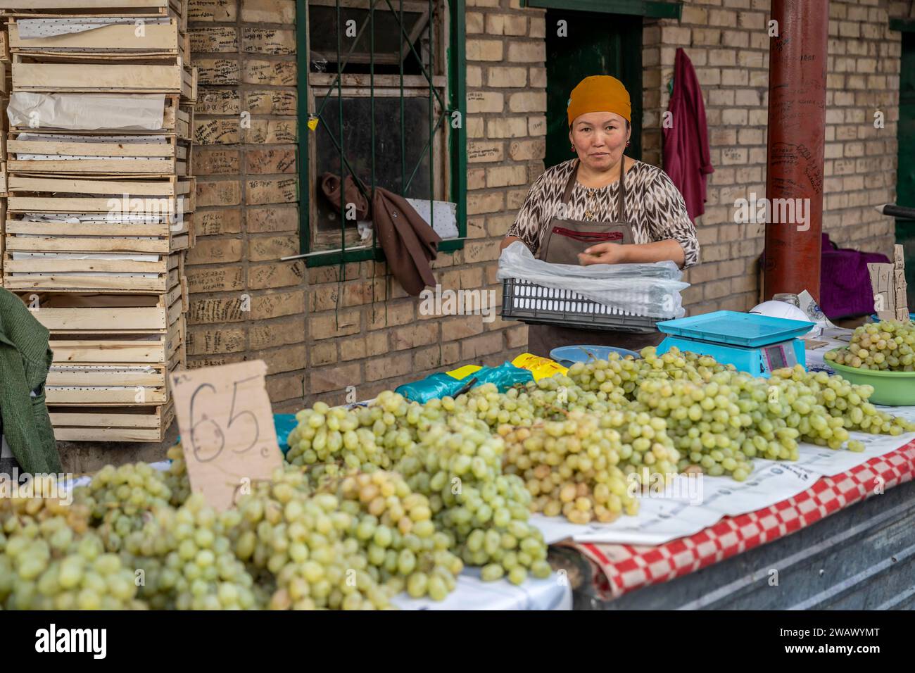 Fruit stall, woman selling grapes at the Osh bazaar, Bishkek ...