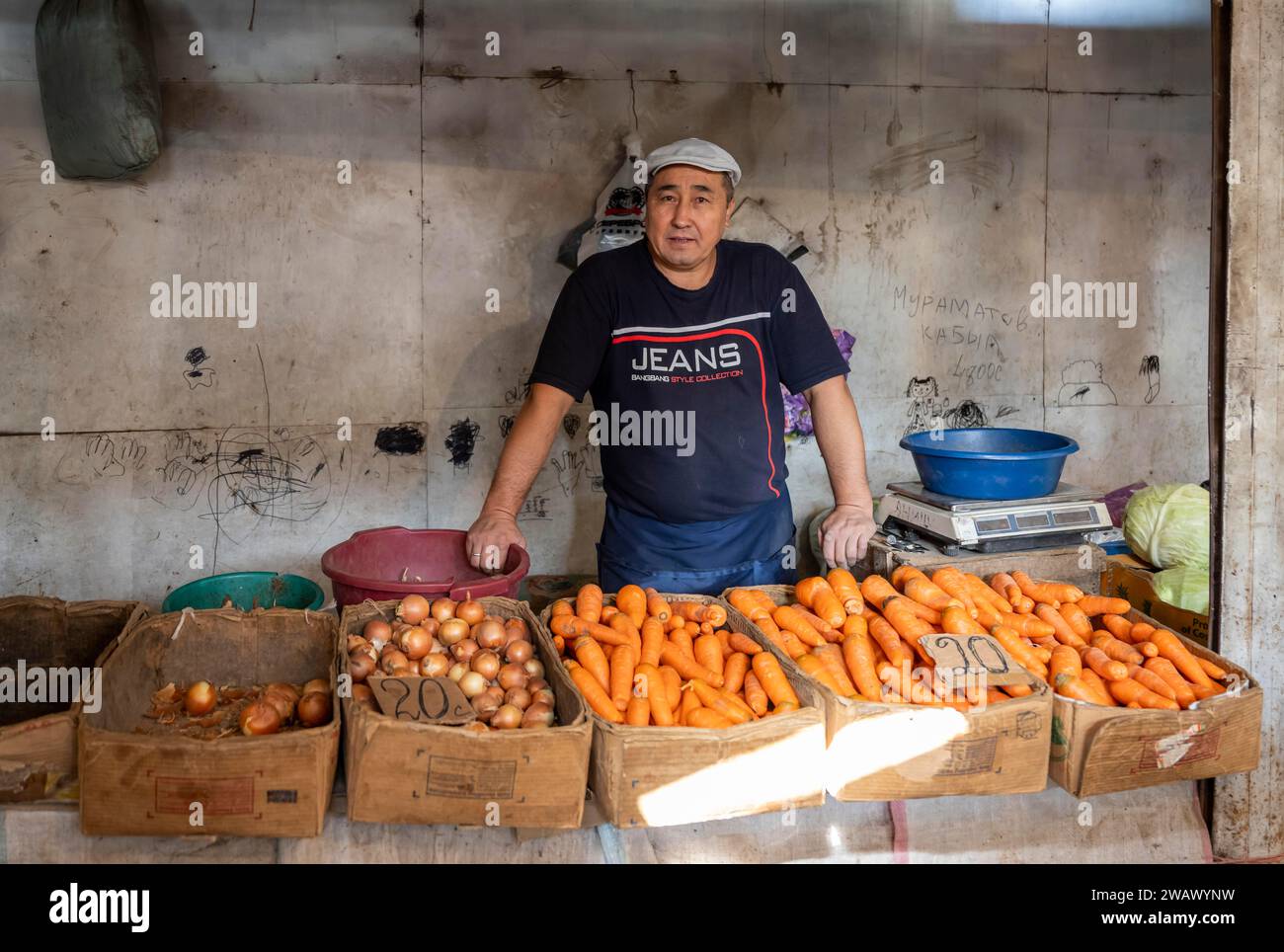 Man selling carrots and onions, vegetable stall at the Osh Bazaar ...