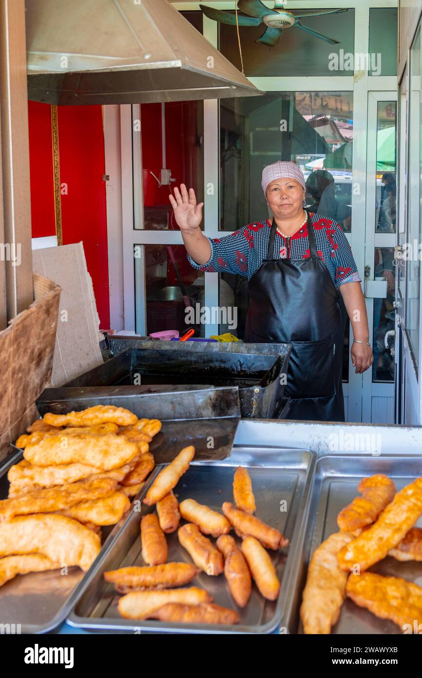 Vendor at the market stall selling pastries, Uzgen Bazaar, Oesgoen, Osh ...