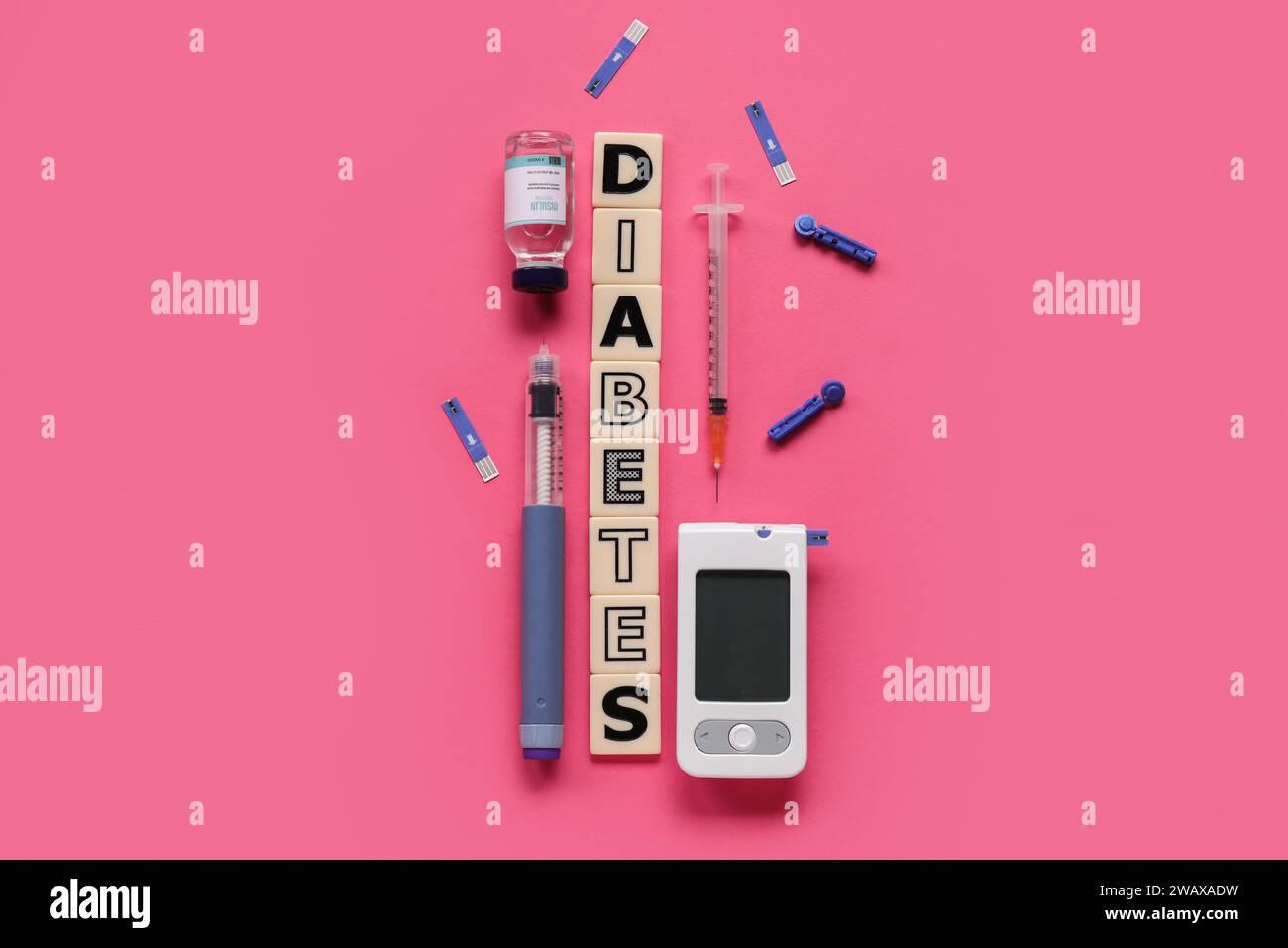 Word DIABETES with insulin, glucometer and lancet pen on pink ...