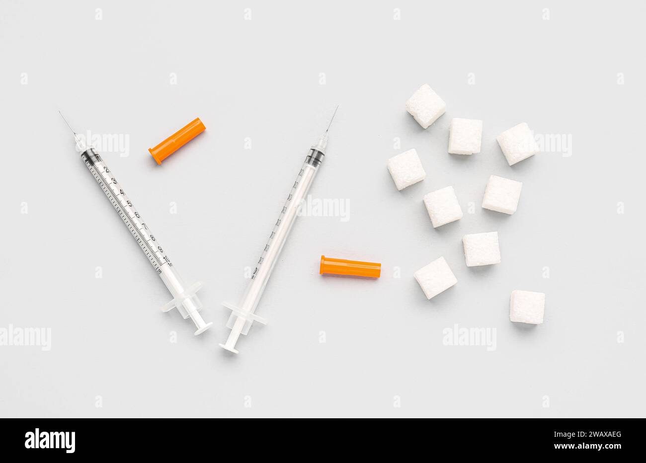 Sugar cubes with syringes for insulin injection on white background ...