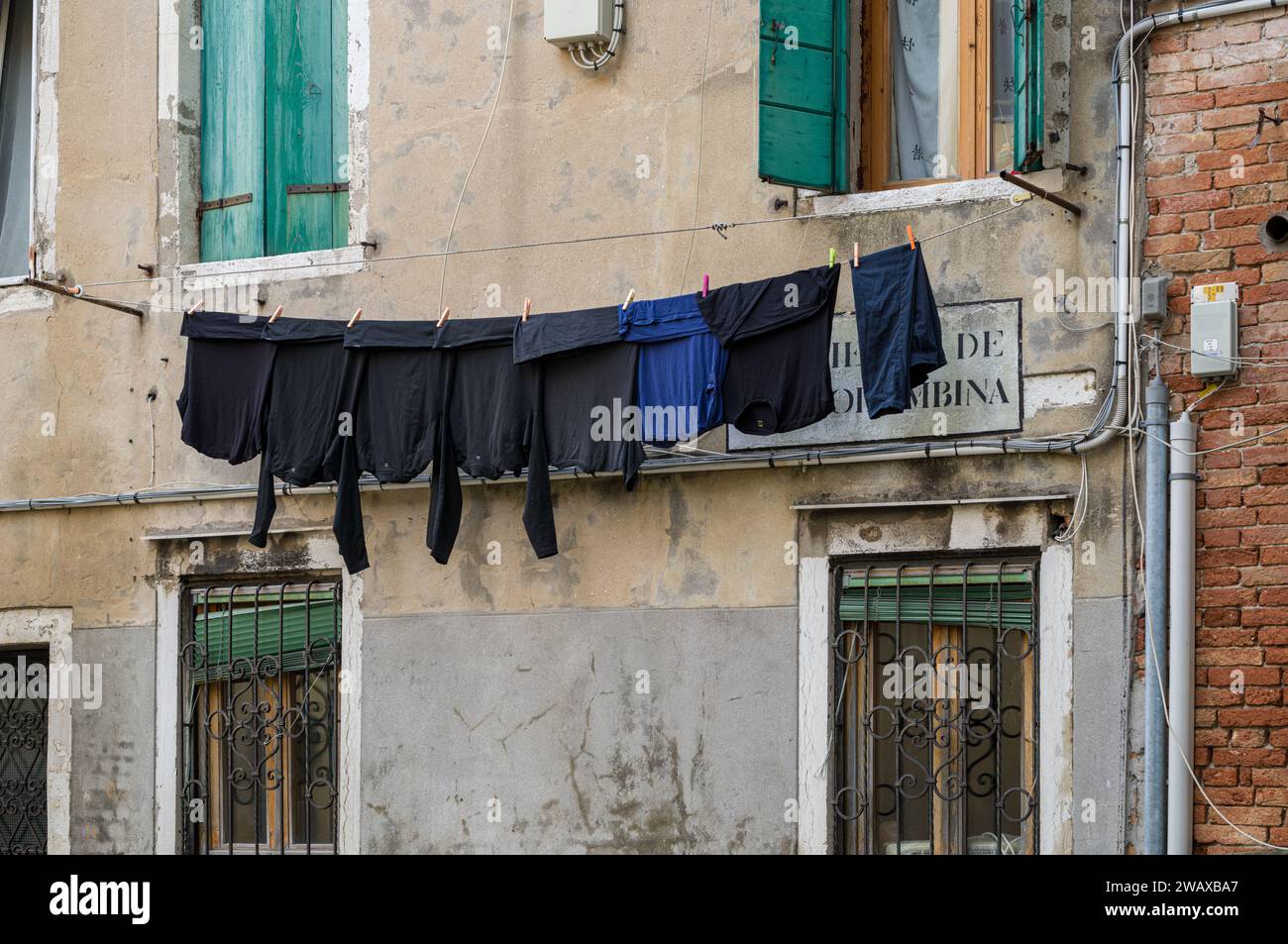 A washing line with black laundry, as it is hung on the walls of old ...