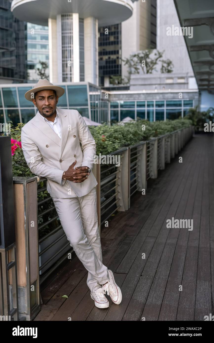 An attractive groom at an international wedding in a light suit with ...