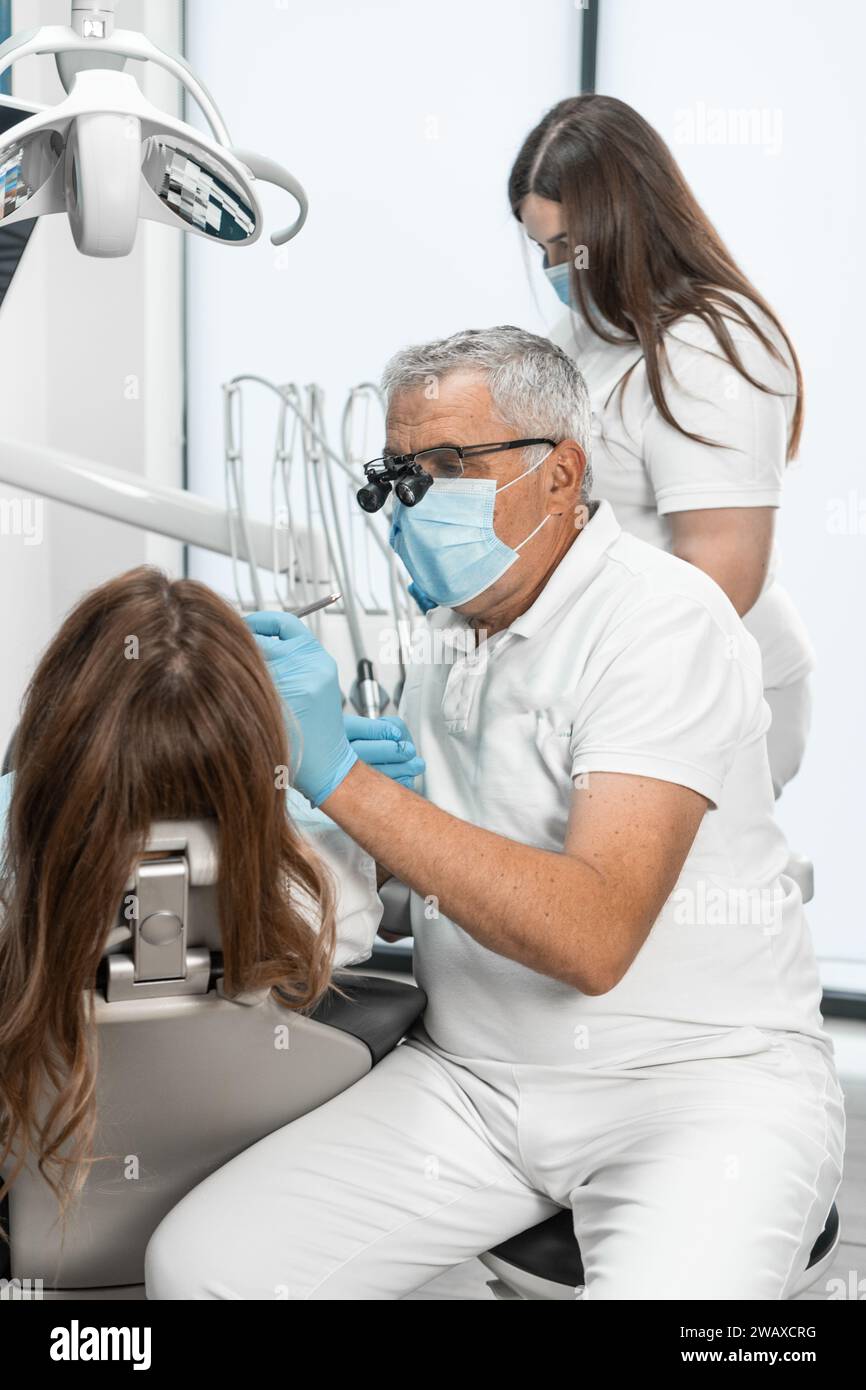 The dentist works in a modern and bright clinic, creating a pleasant ...