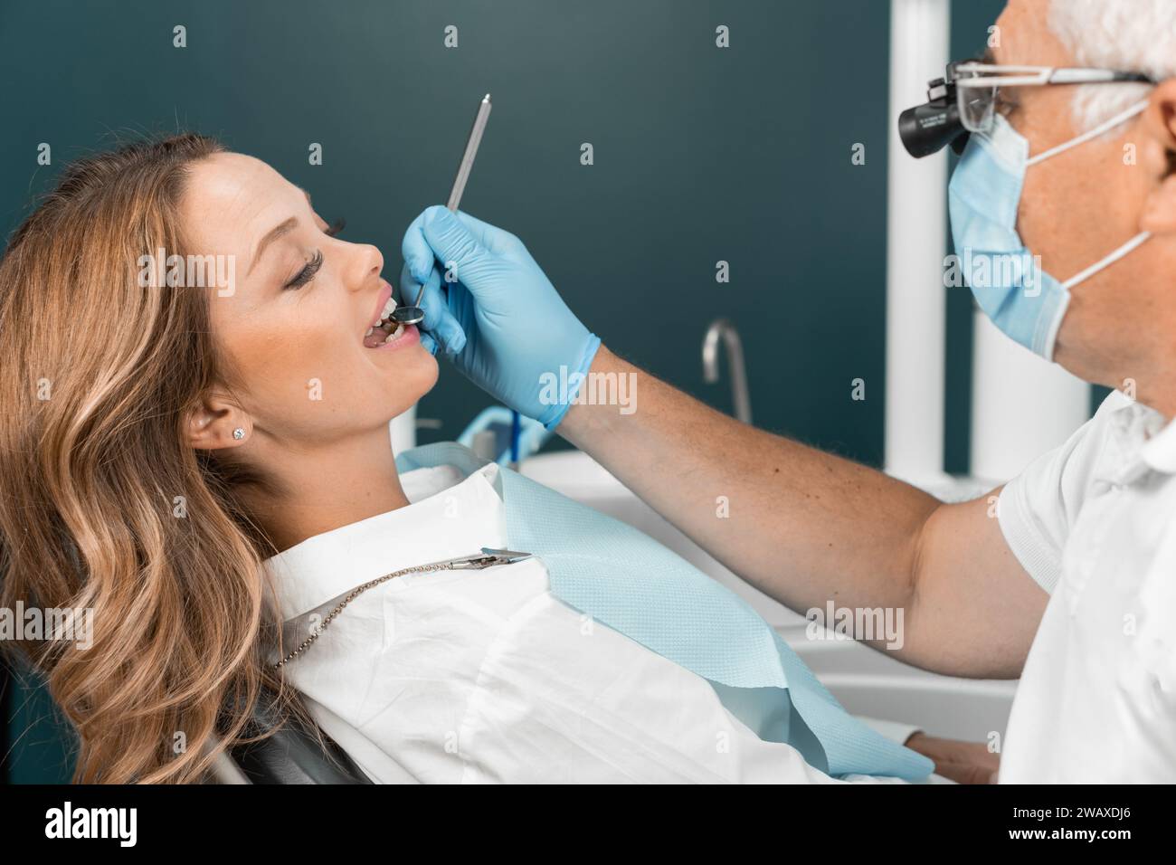 The dentist examines the patient's teeth with great attention and ...