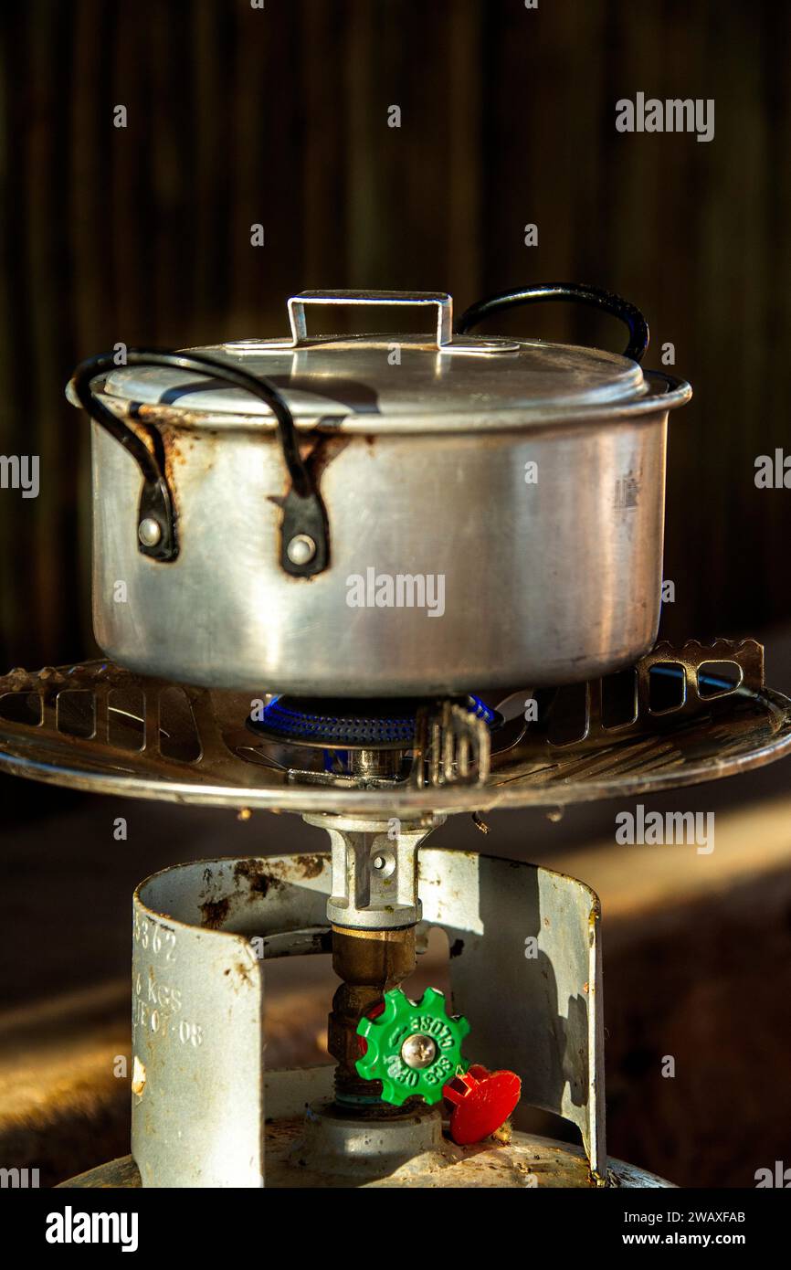 An old aluminium pan with lid heating up on a gas bottle stove Stock ...