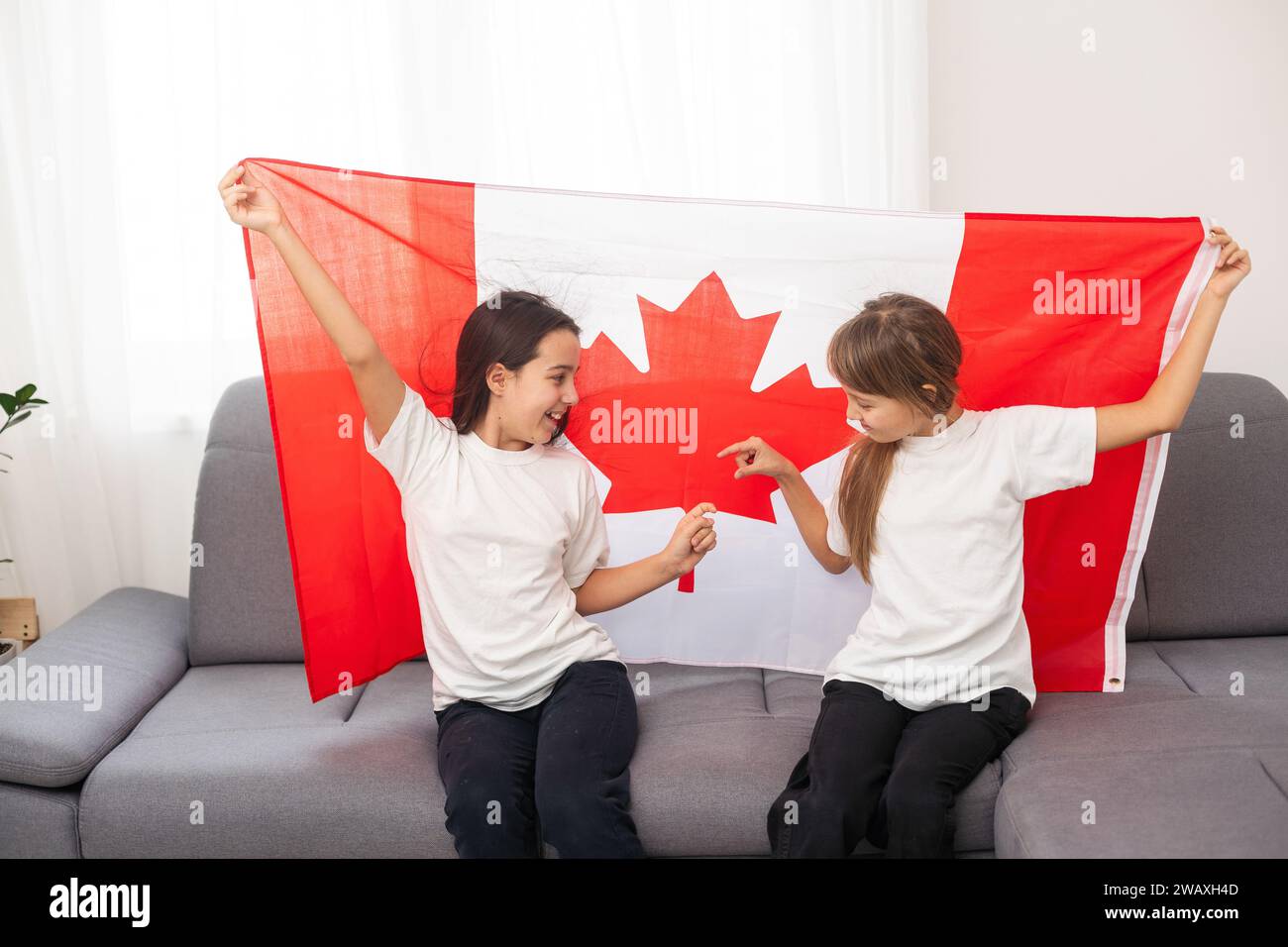 Happy Canada Day Celebration. Two girls with big Canada flag in their ...
