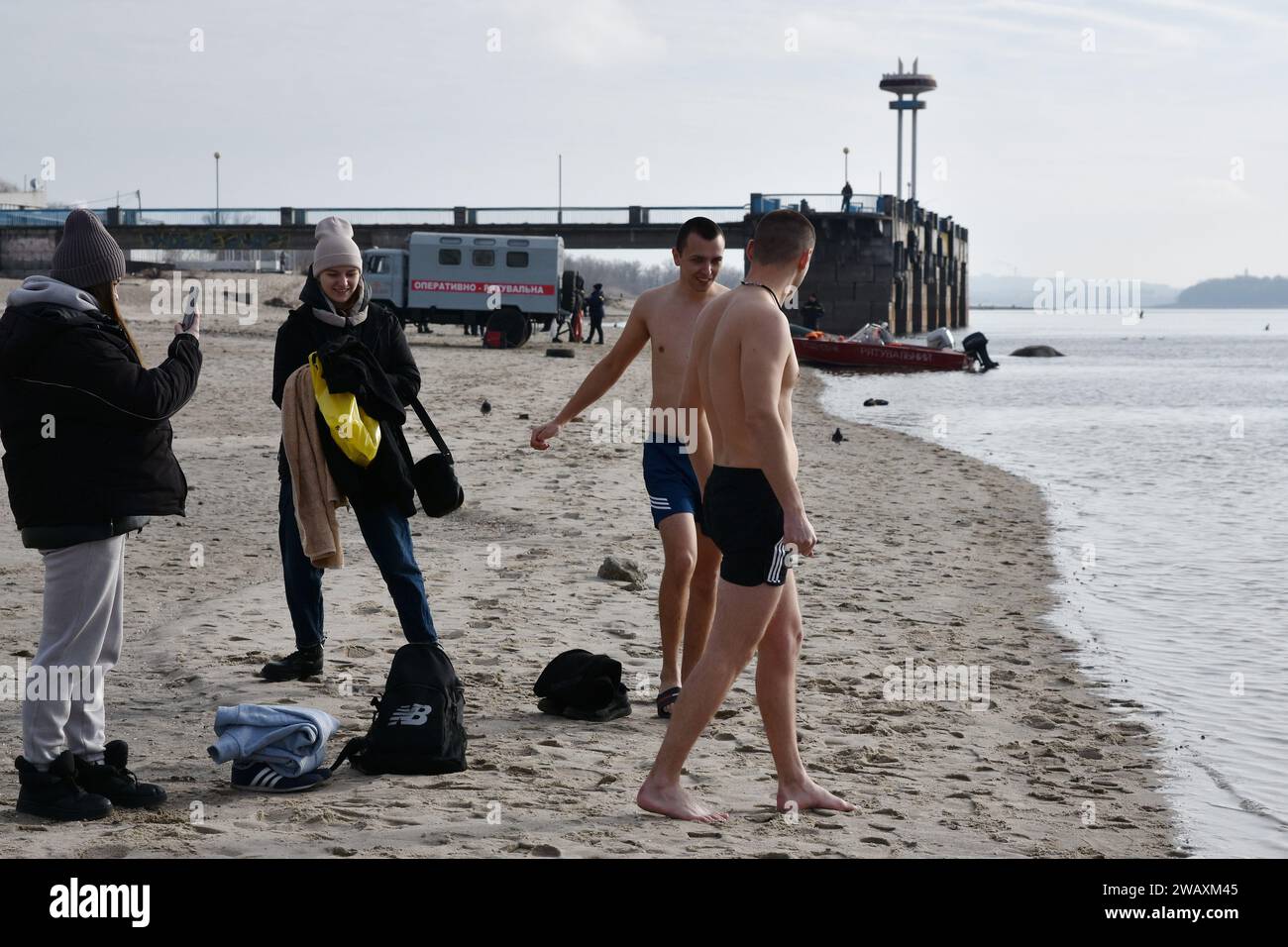 Two men prepare to dip in cold water of the Dnipro river during the ...