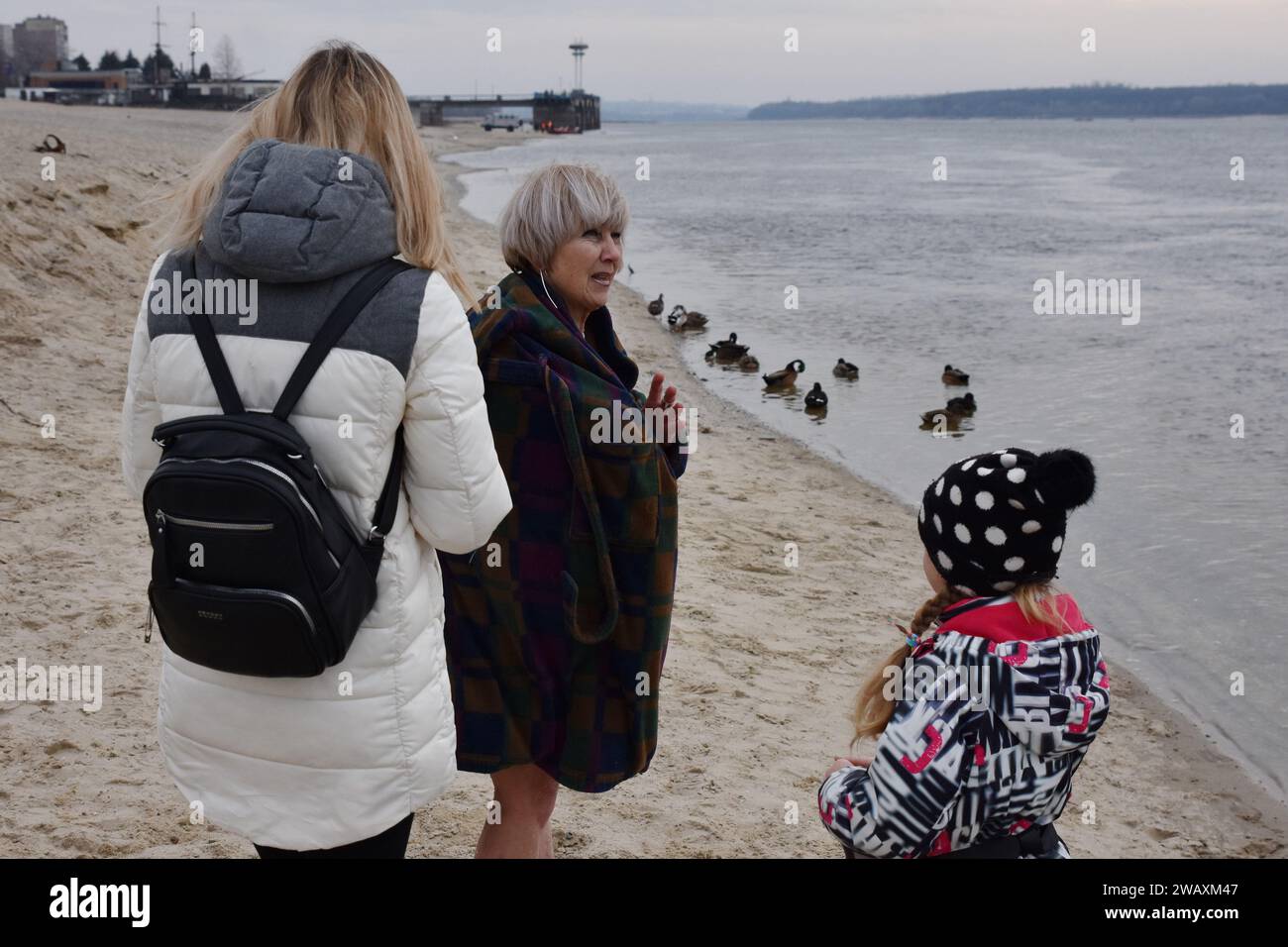 An elderly woman prepares to dip in cold water of the Dnipro river ...