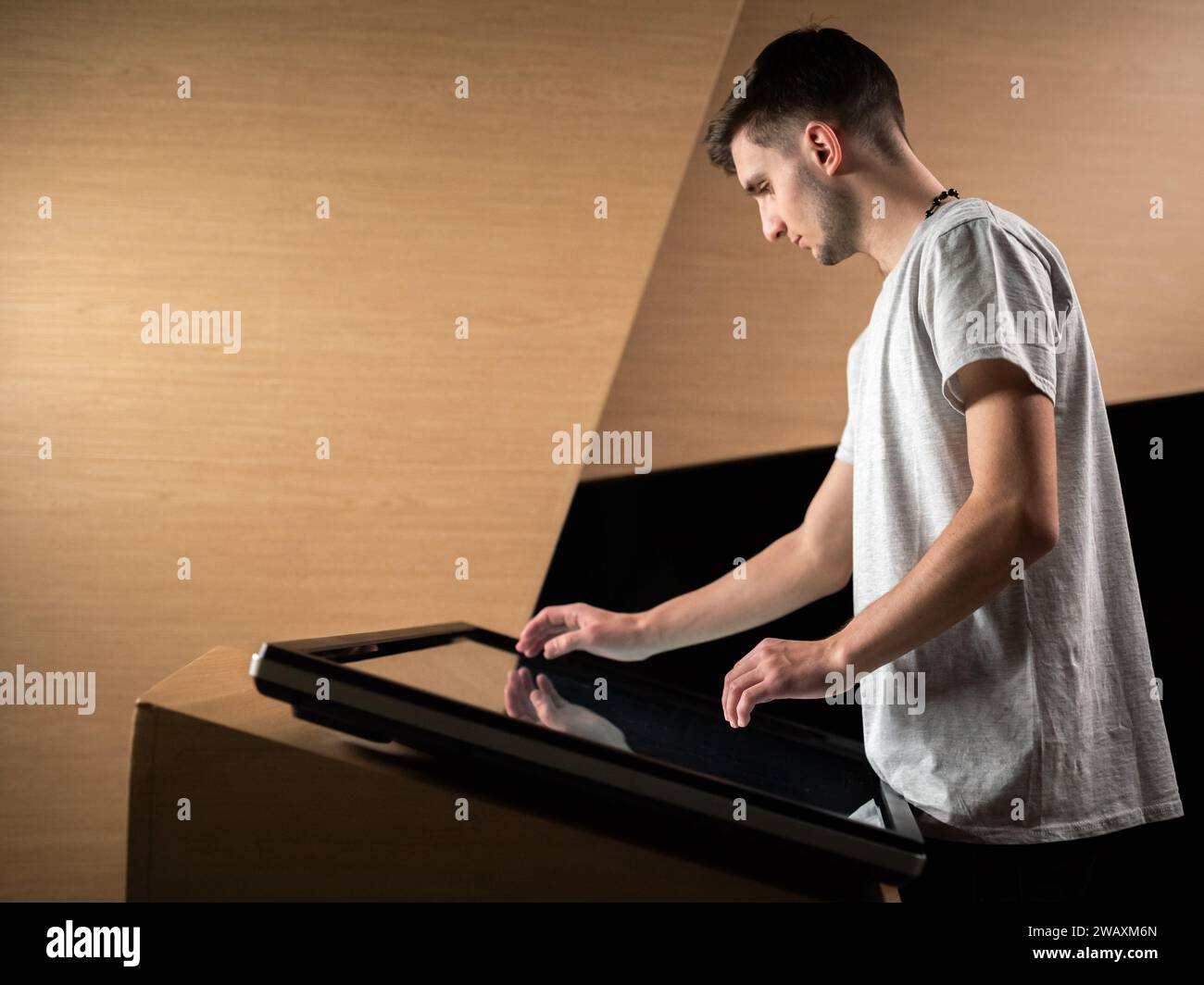 Young man standing in front of a touch screen board and making ...