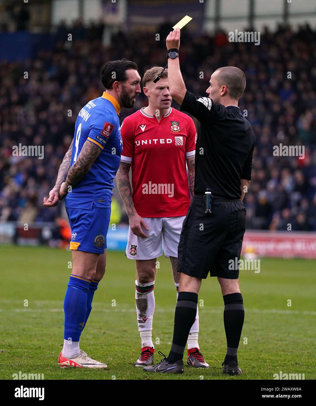 Referee Andrew Kitchen shows a yellow card to Shrewsbury Town's Ryan ...