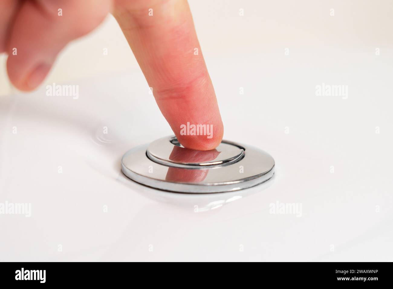 Pressing the toilet flush button in the restroom close up Stock Photo ...