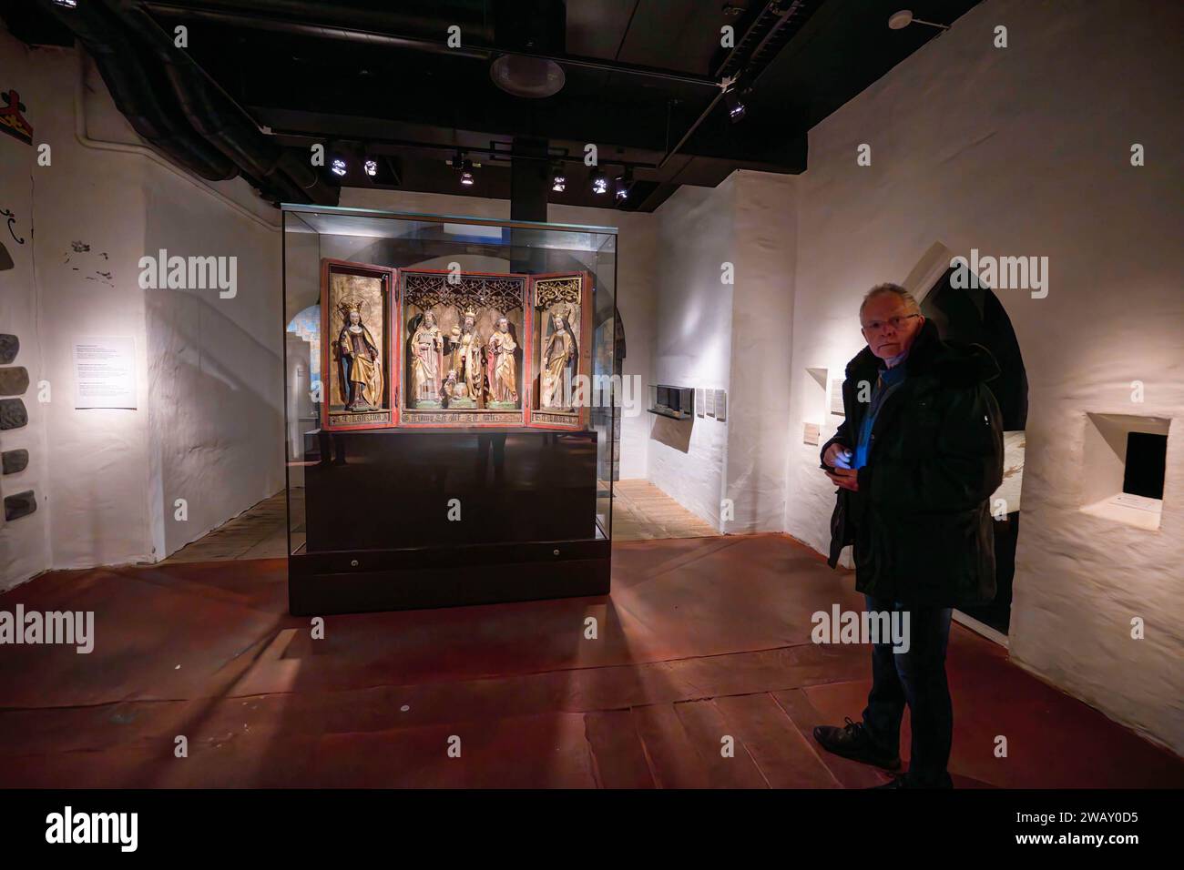 A man seen through one of the rooms displaying artifacts and sculptures ...