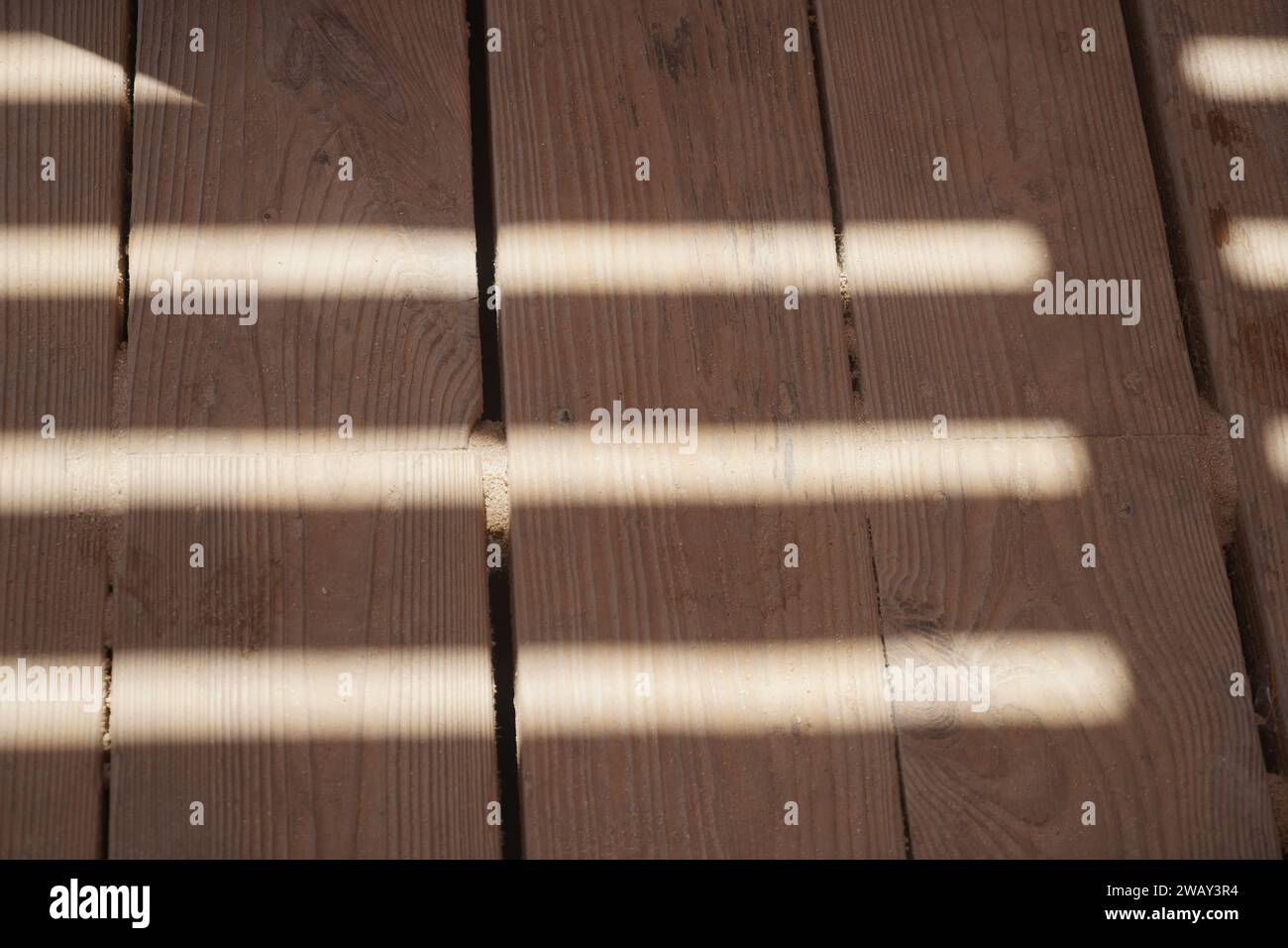 a horizontal shadow cast on a wooden floor, creating captivating grid ...