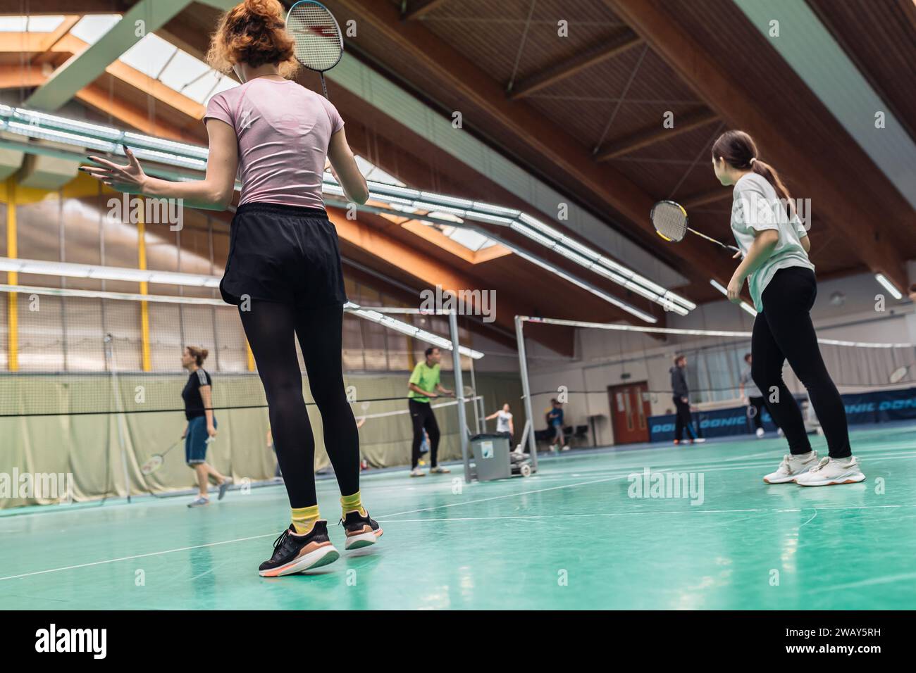 Indoor sports. People different ages play badminton on sports court ...