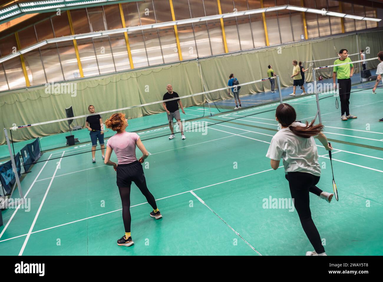 Indoor sports. People different ages play badminton on sports court ...