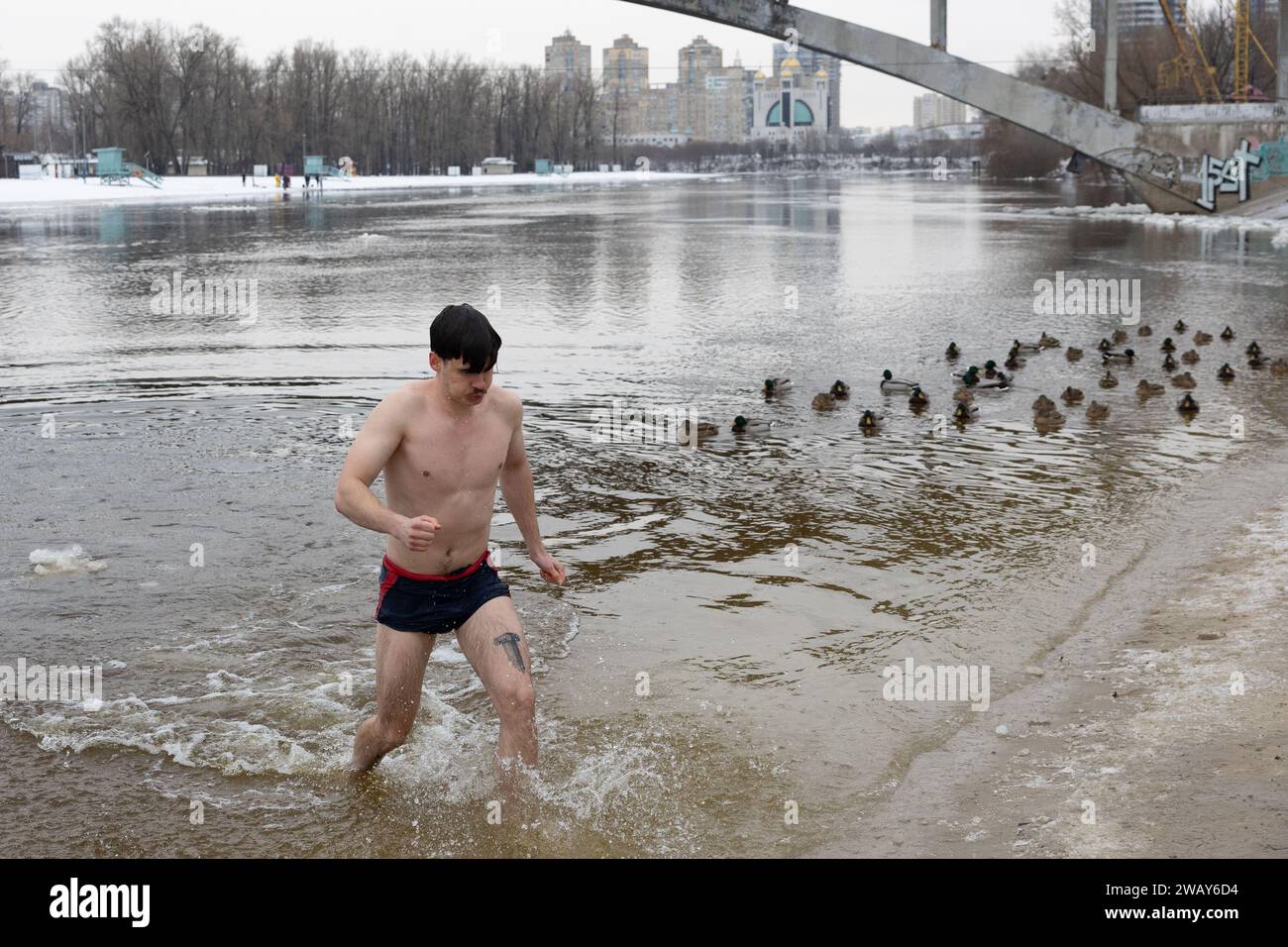 A man comes out of the water after swimming in cold Dnipro River on the ...