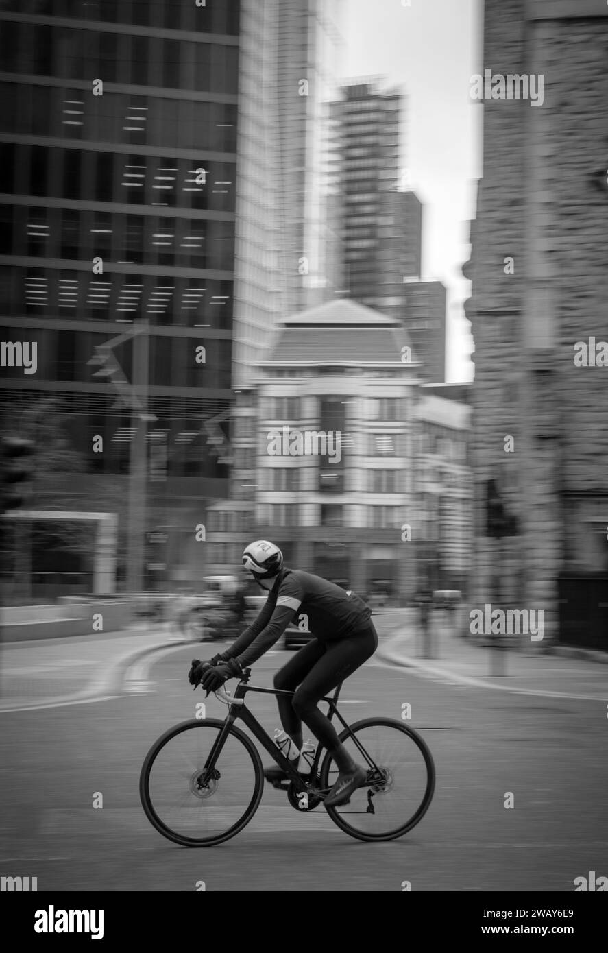 A cyclist on a road bike speeds along the road near Liverpool Street in ...