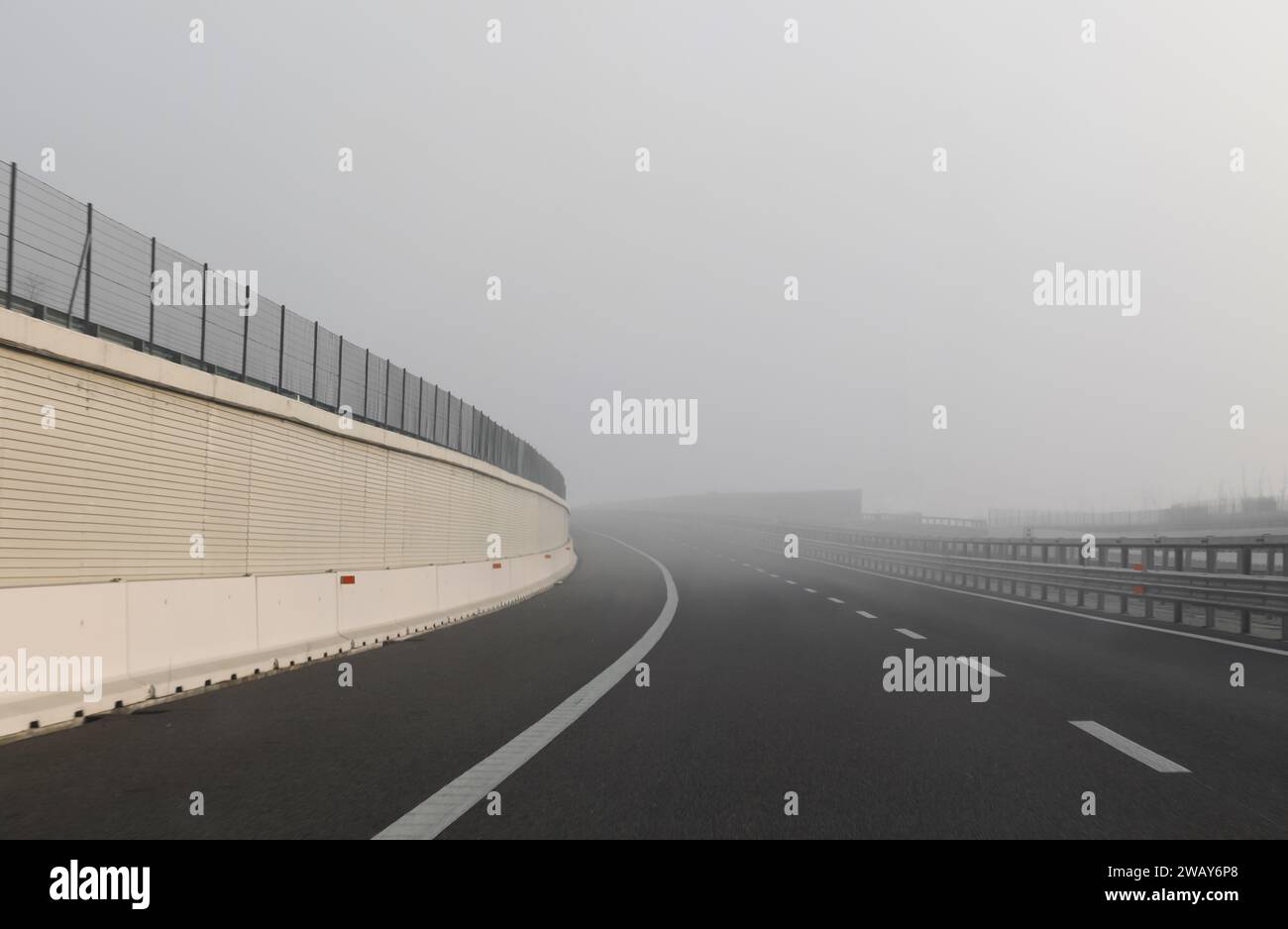 wide lane of motorway without cars but with a lot of dangerous fog ...