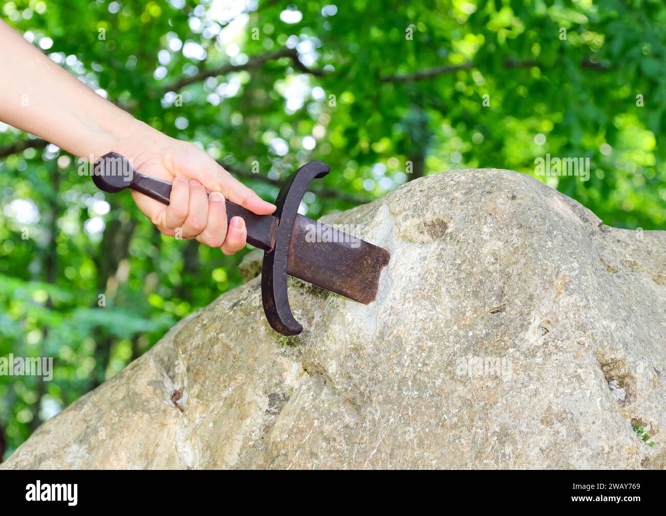 hand of the knight who tries to extract the Excalibur Sword stuck in ...