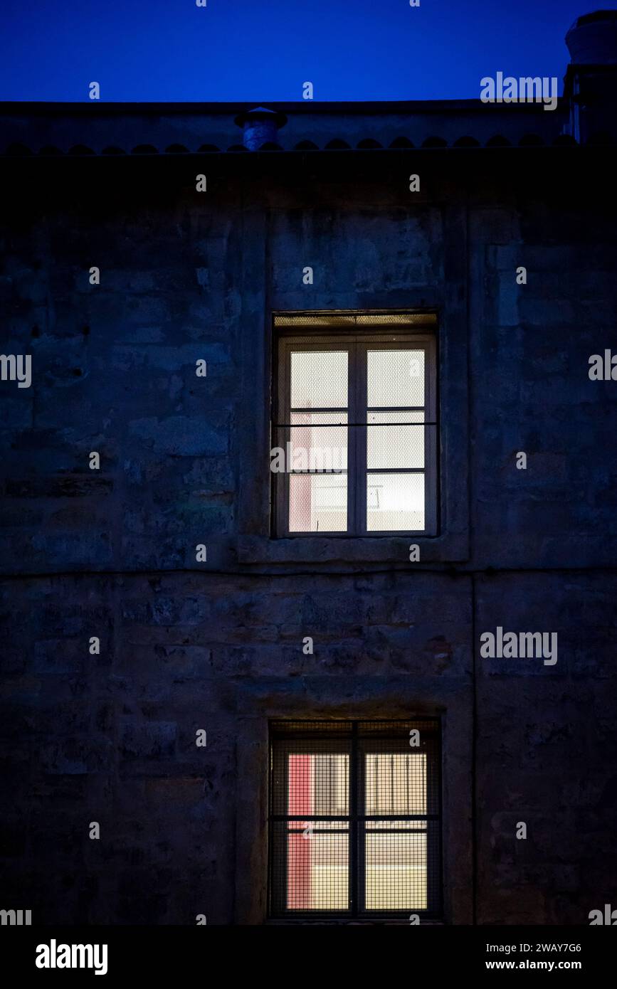 Two windows lit in a house at night in a Street in Montpellier, France ...