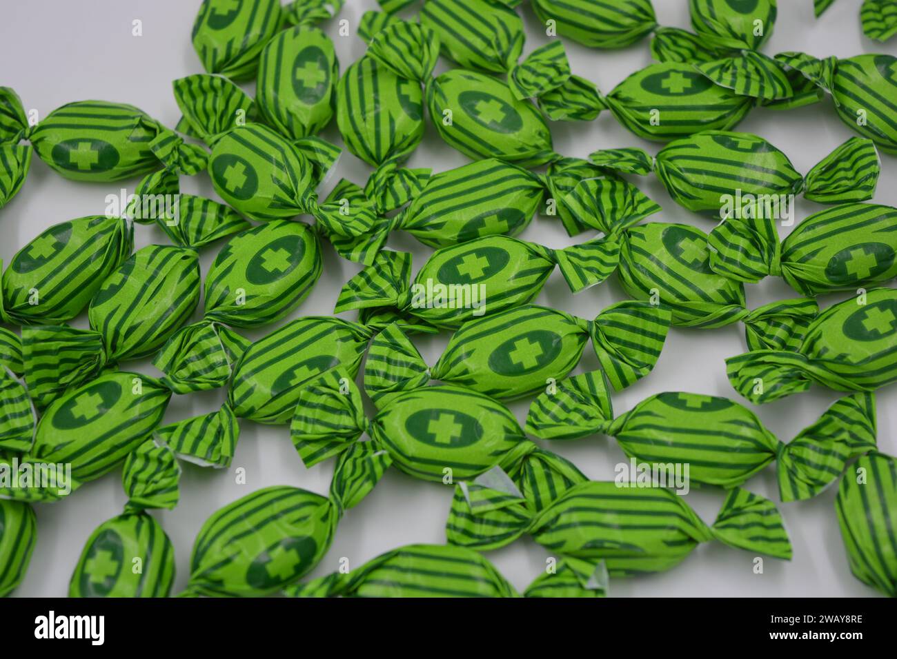 Bright, colorful factory menthol candies packed in green packaging with ...