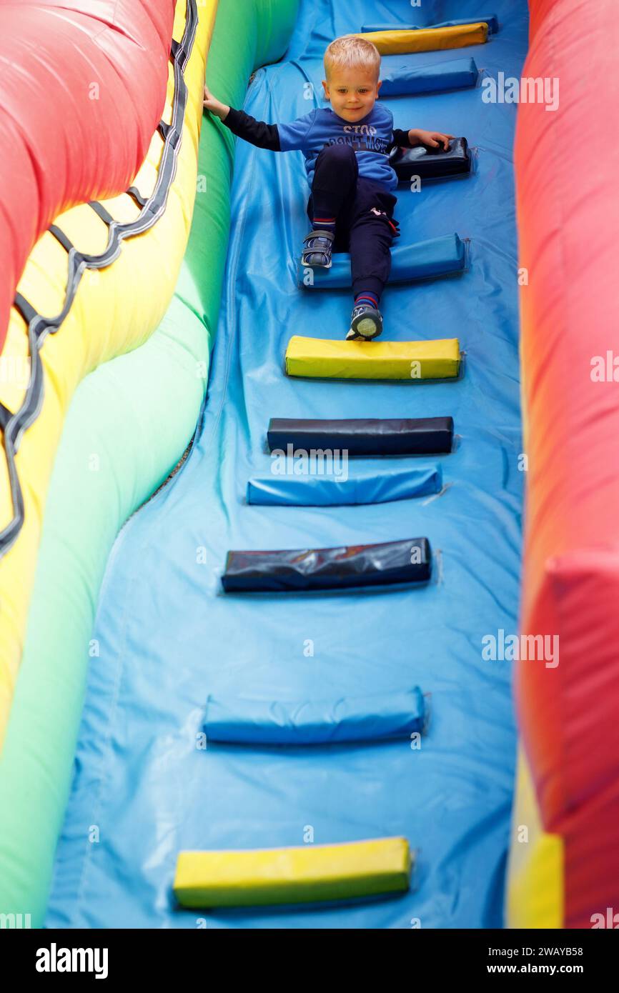 A boy climbs down the stairs of a tall bouncy castle Stock Photo - Alamy