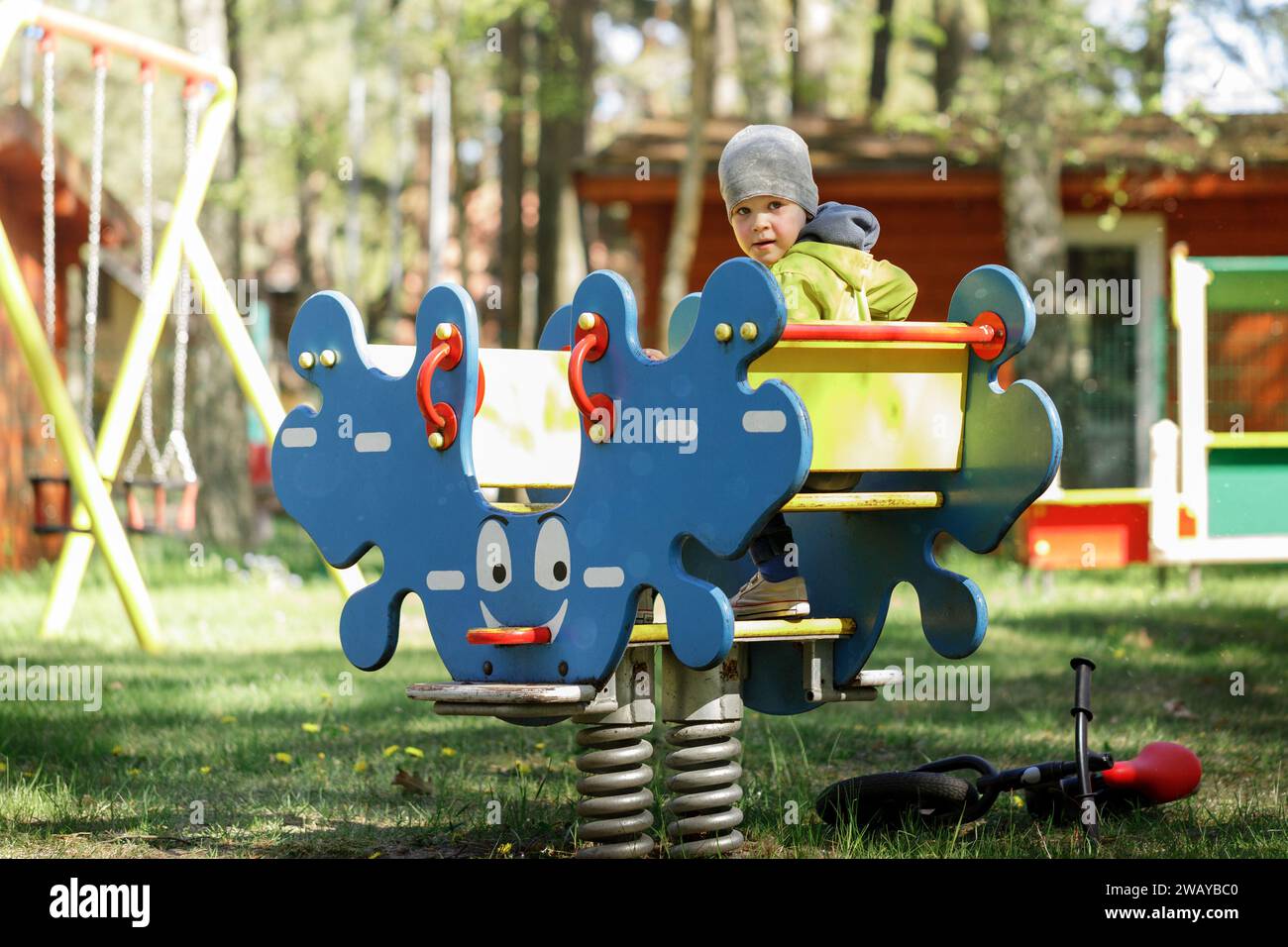 Little boy on colorful playground, attraction with a spring Stock Photo ...