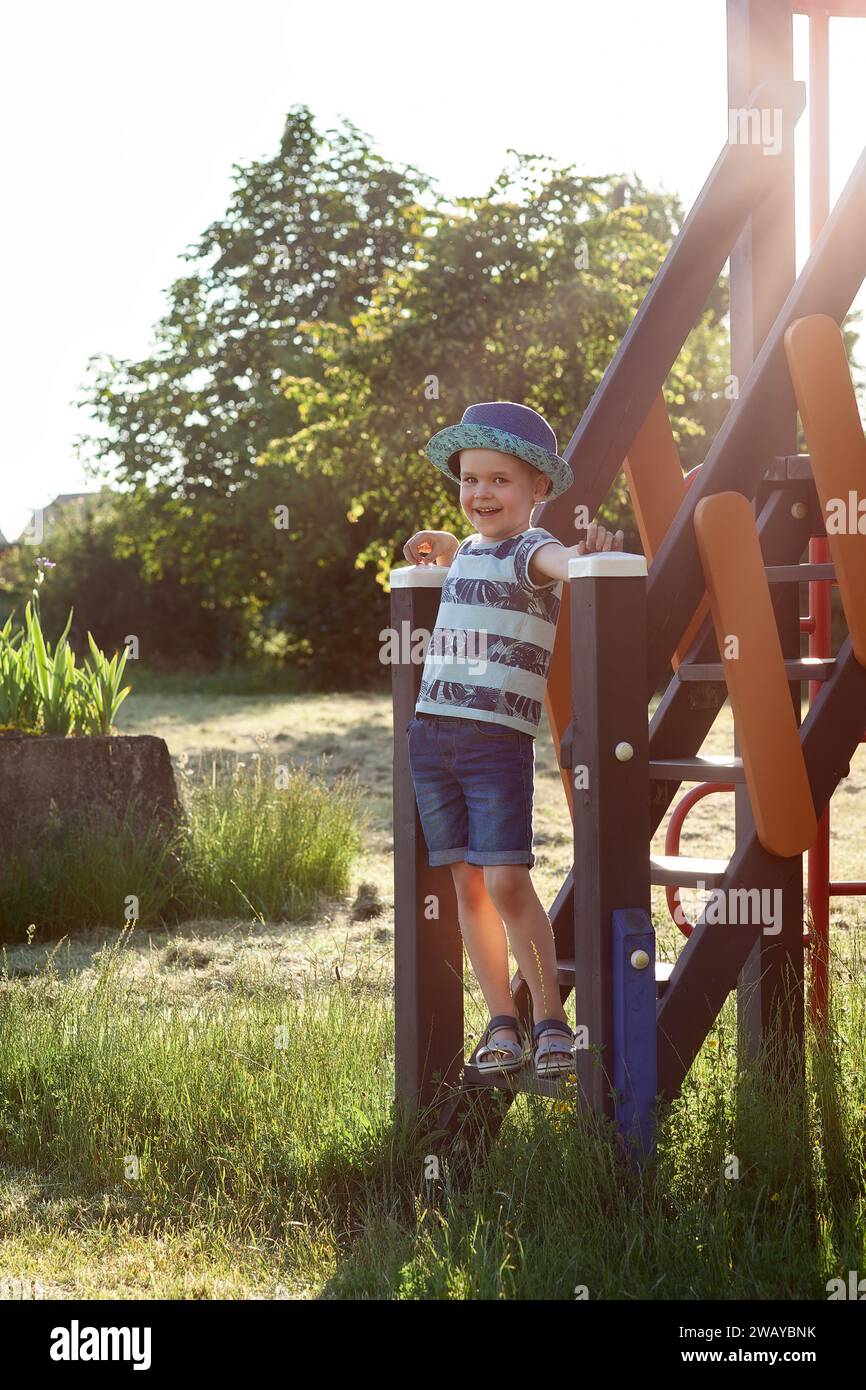Happy little boy posing and smiling on wooden playhouse steps. A lovely ...